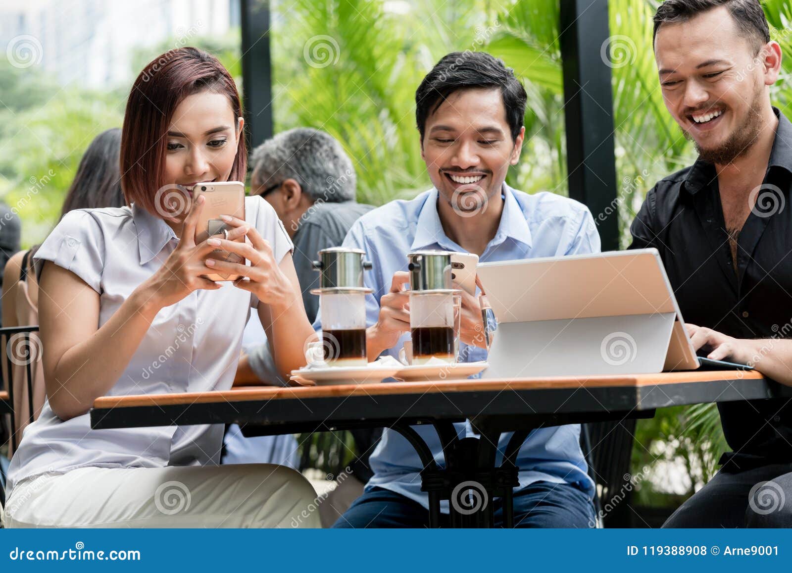 Friends Using Devices Connected To the Wireless Internet of a Modern ...