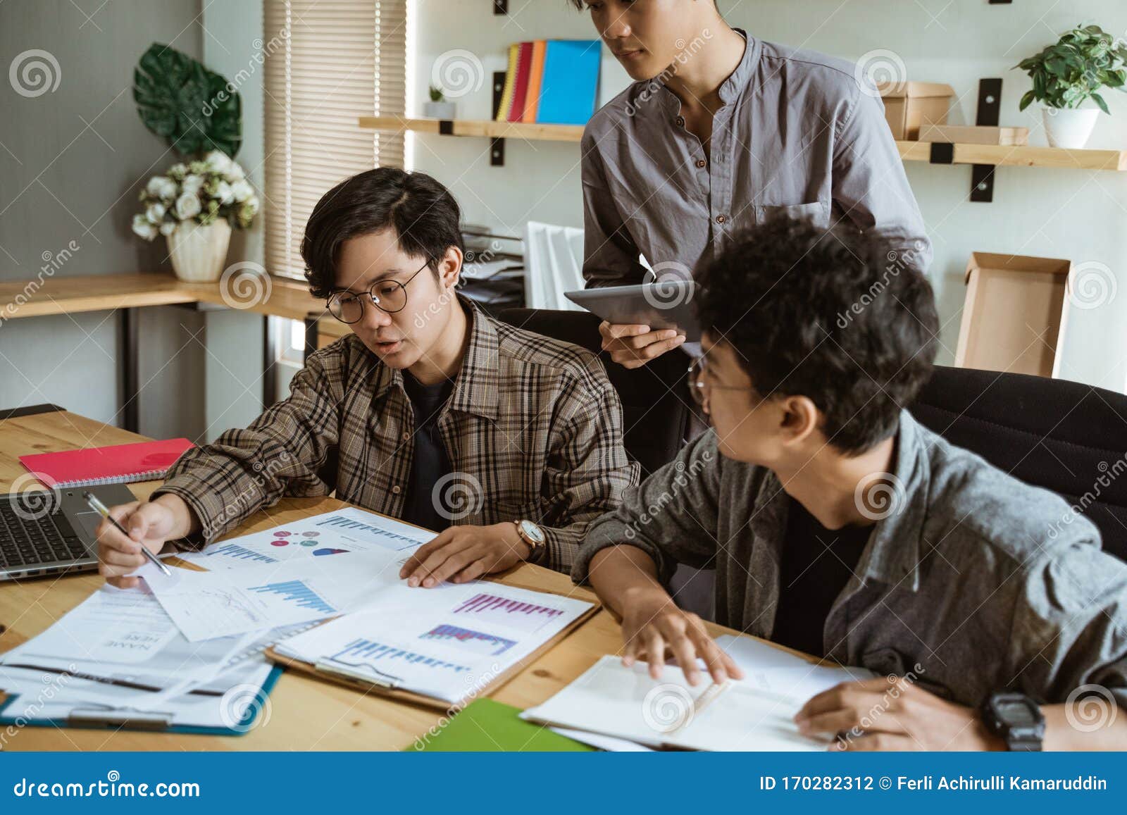 Three Young Asian Worker Chatting about Their Product Stock Photo ...
