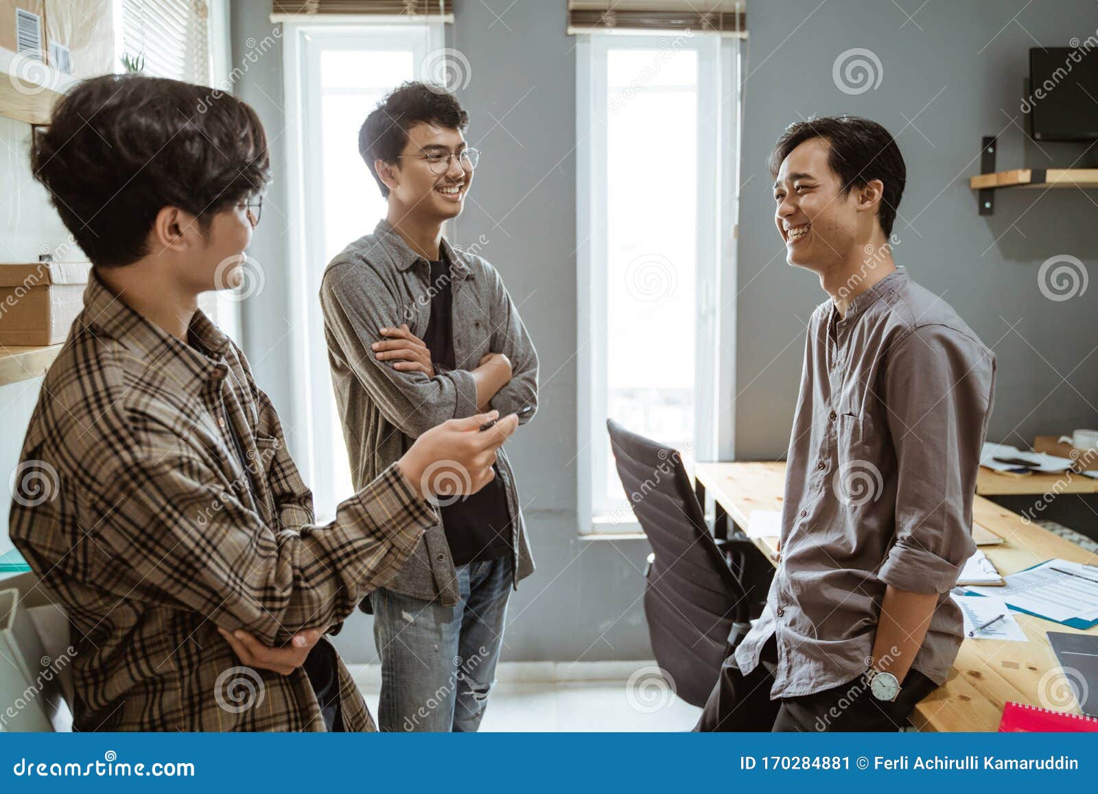 Three Young Asian Worker Chatting about Their Product Stock Image ...