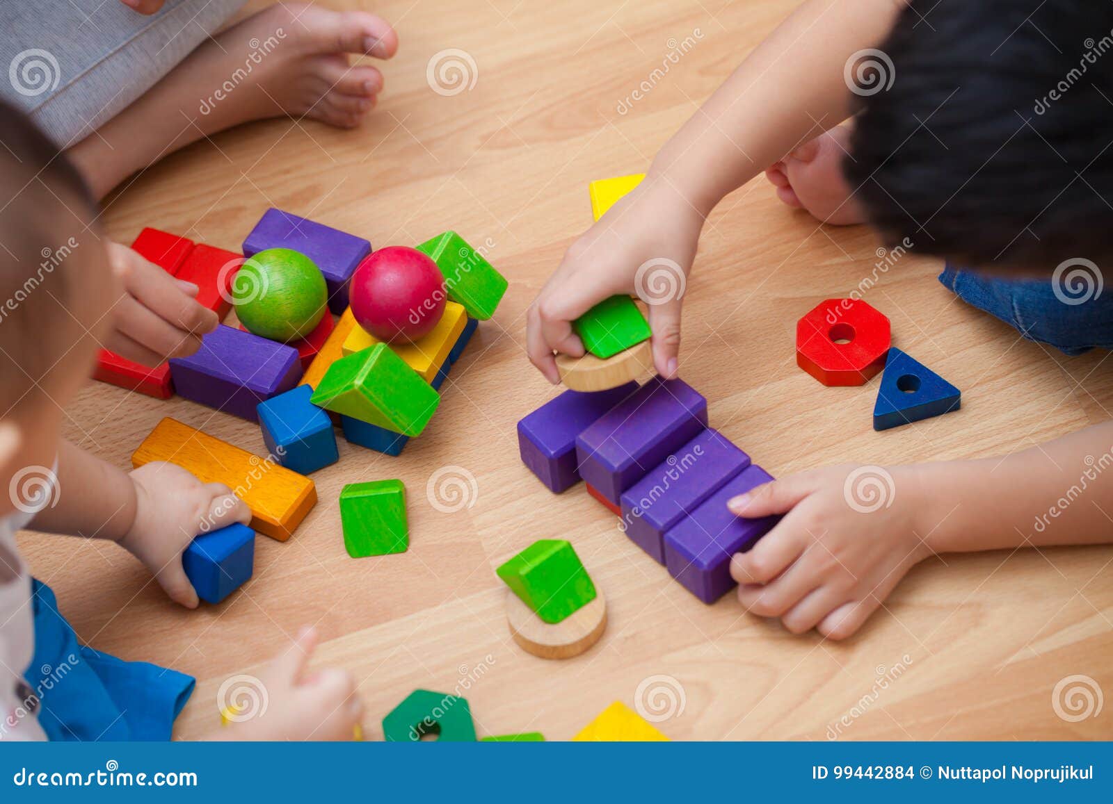 Three Young Children Playing with Wooden Blocks in the Room. Stock ...