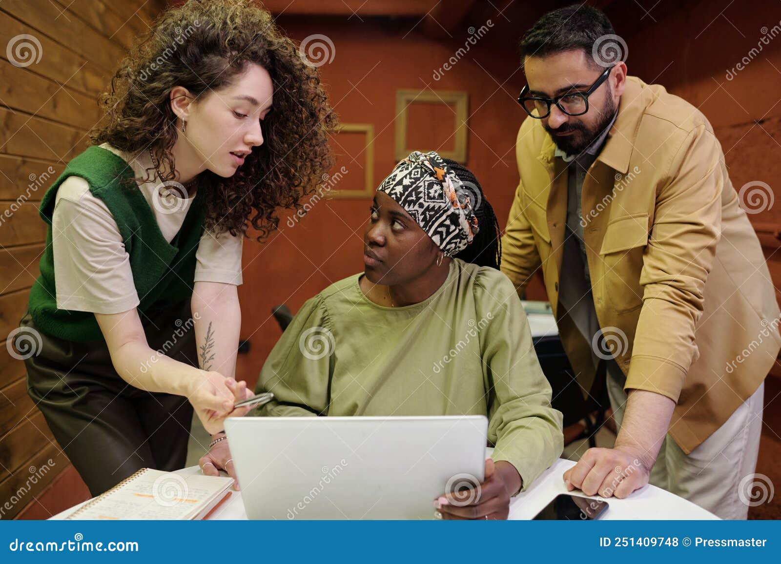 Three Young Intercultural Employees Gathered by Workplace in Front of ...