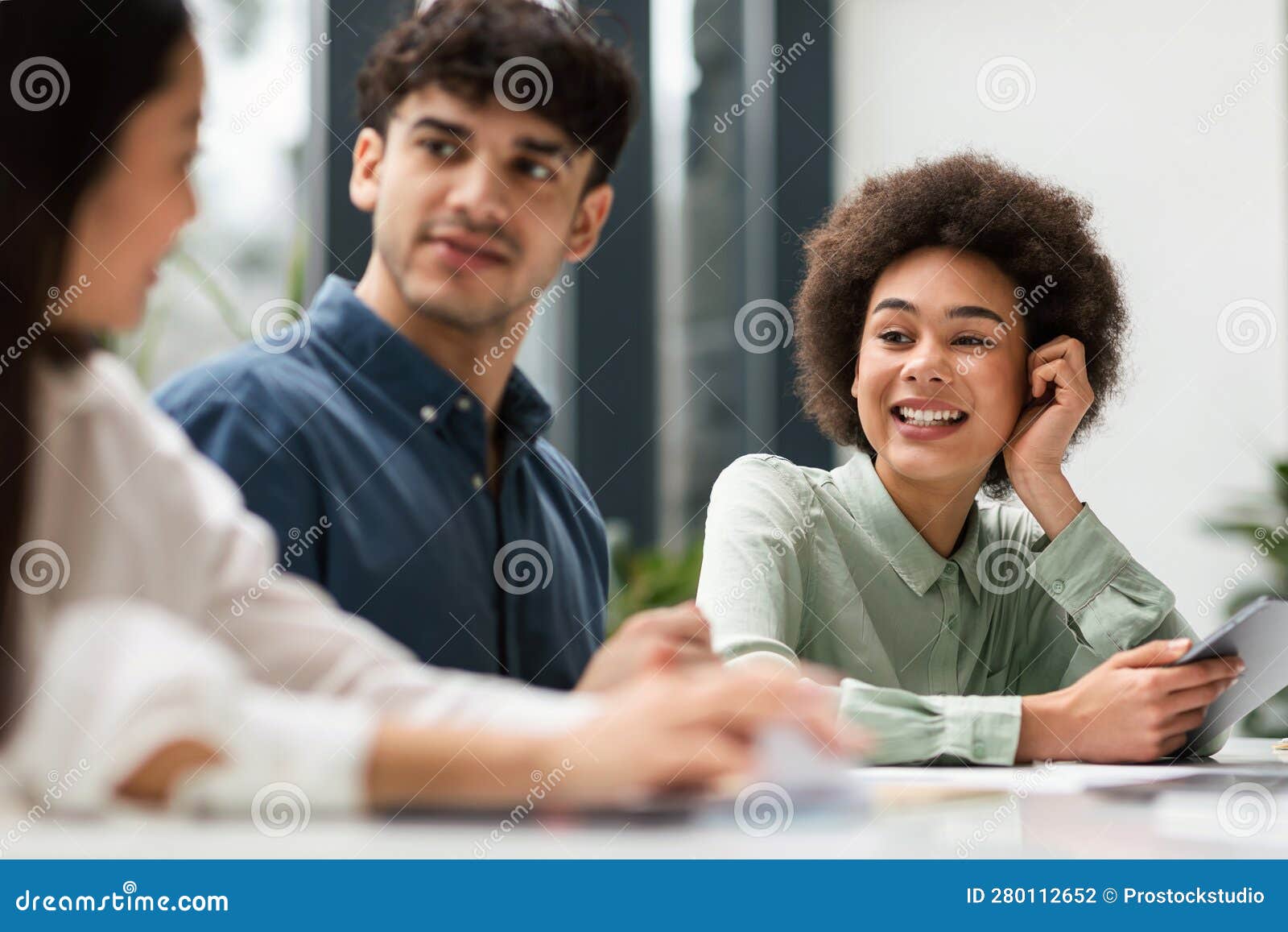 Three Young Multiethnic Colleagues Talking Interacting at Workplace in ...