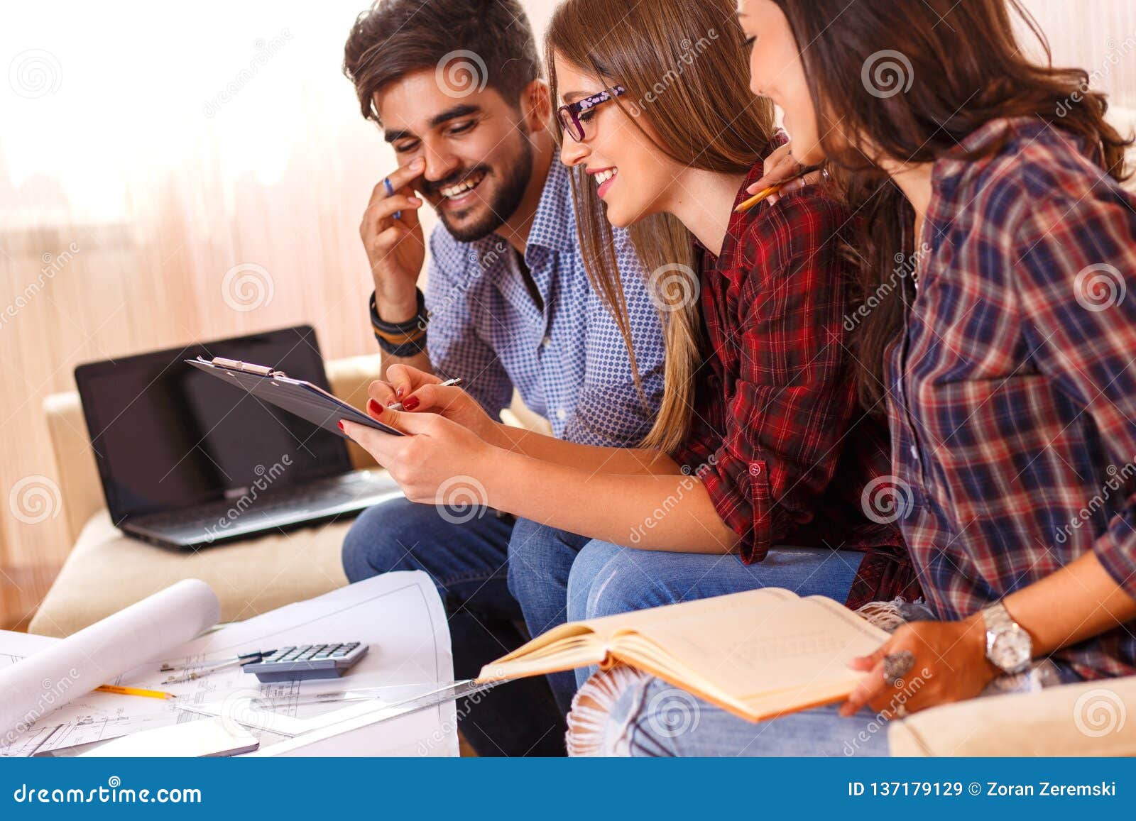 Three Young Students Working Together on a New Project. Stock Image ...