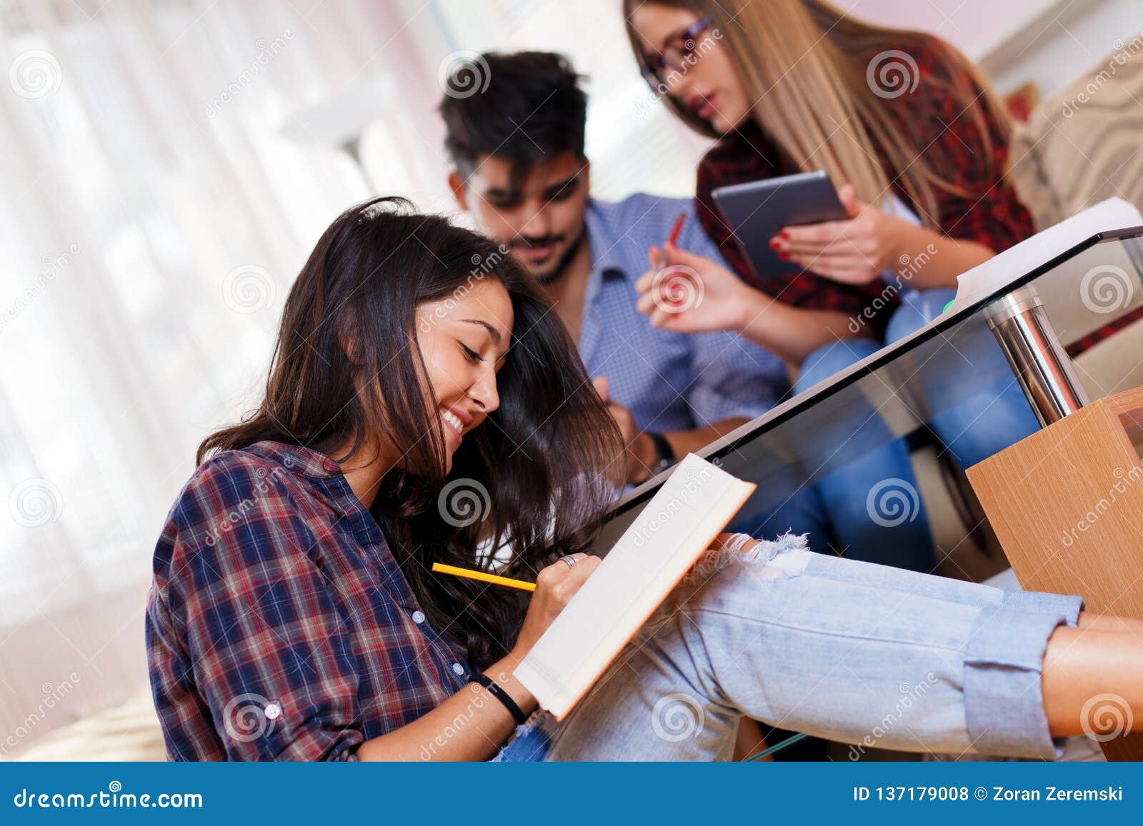 Three Young Students Working Together on a New Project. Stock Photo ...