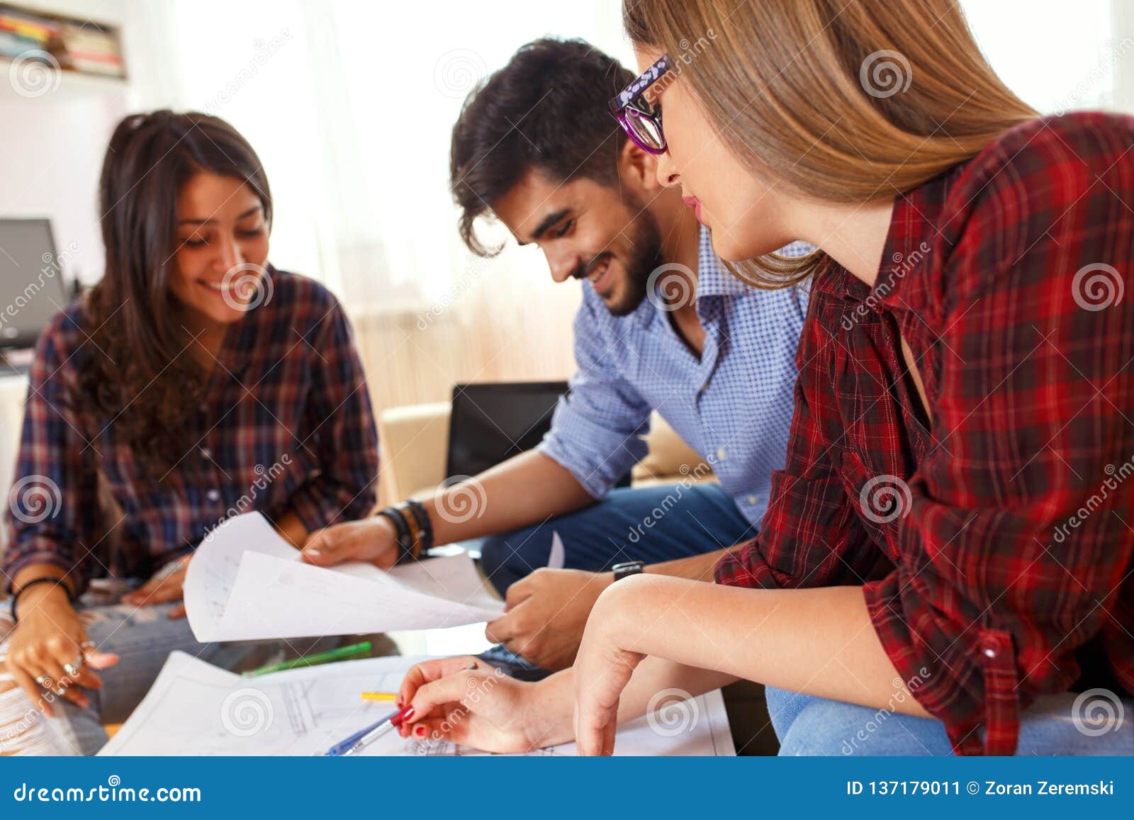 Three Young Students Working Together on a New Project. Stock Image ...