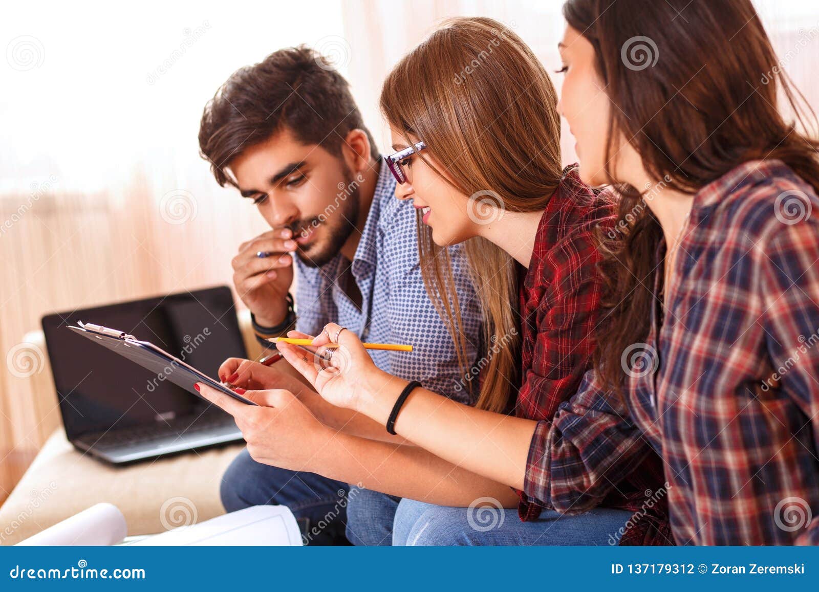 Three Young Students Working Together on a New Project. Stock Photo ...