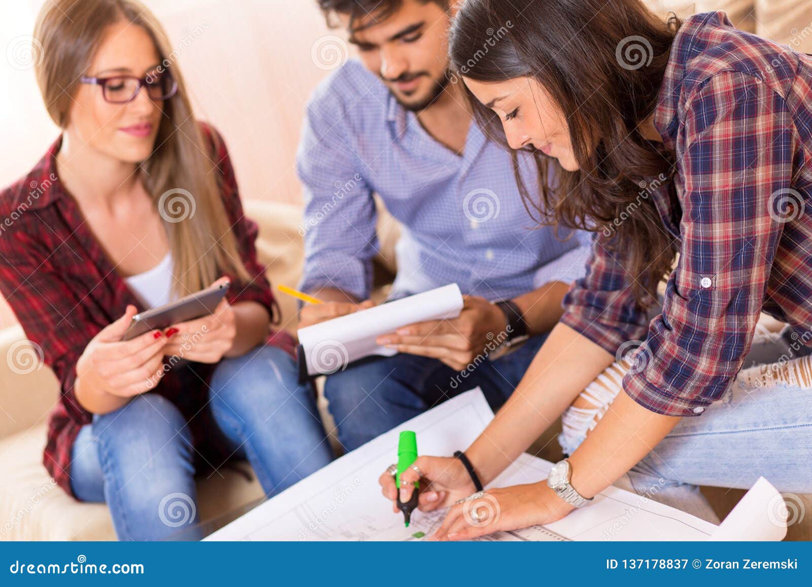 Three Young Students Working Together on a New Project. Stock Image ...