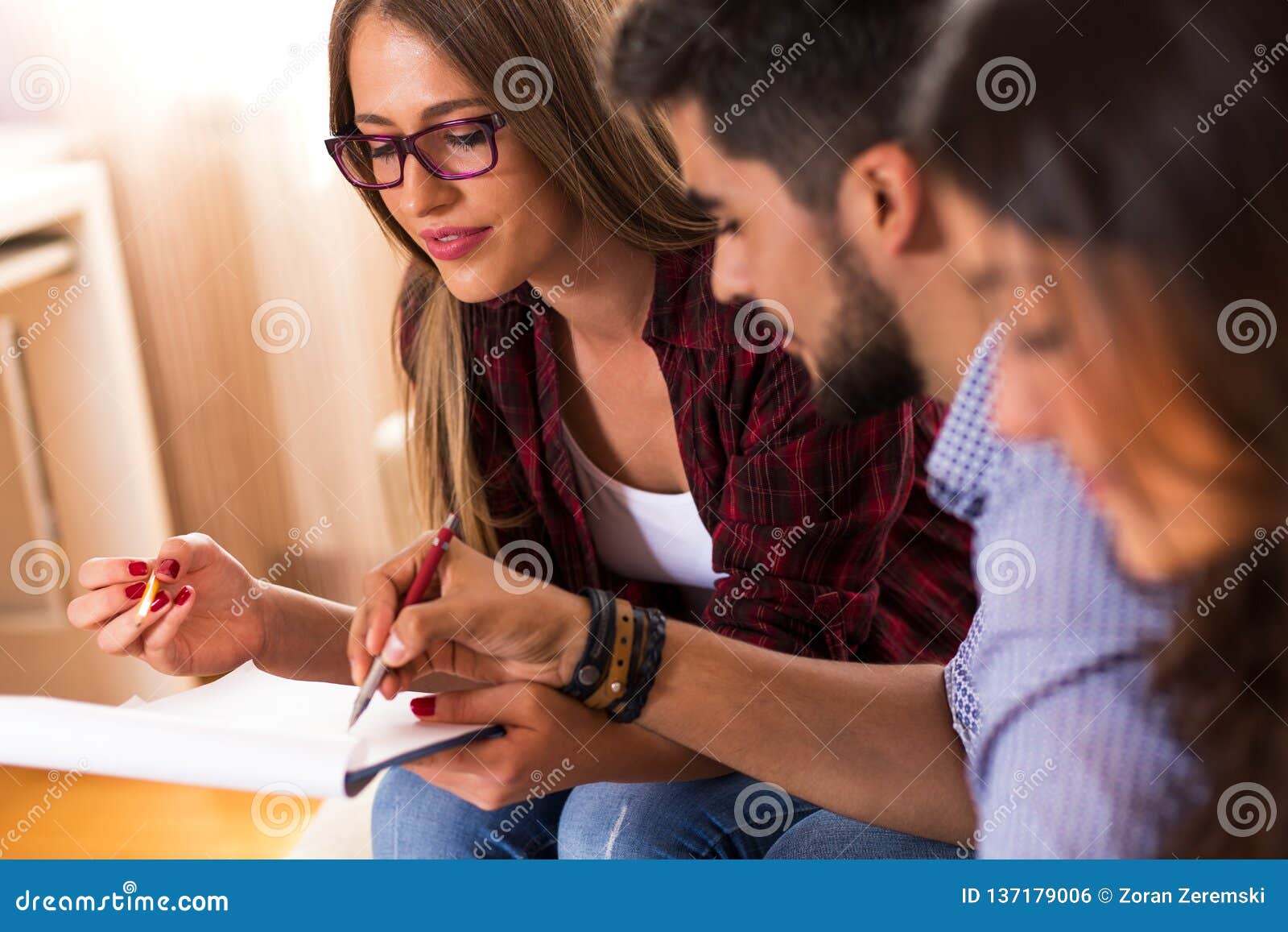 Three Young Students Working Together on a New Project. Stock Photo ...