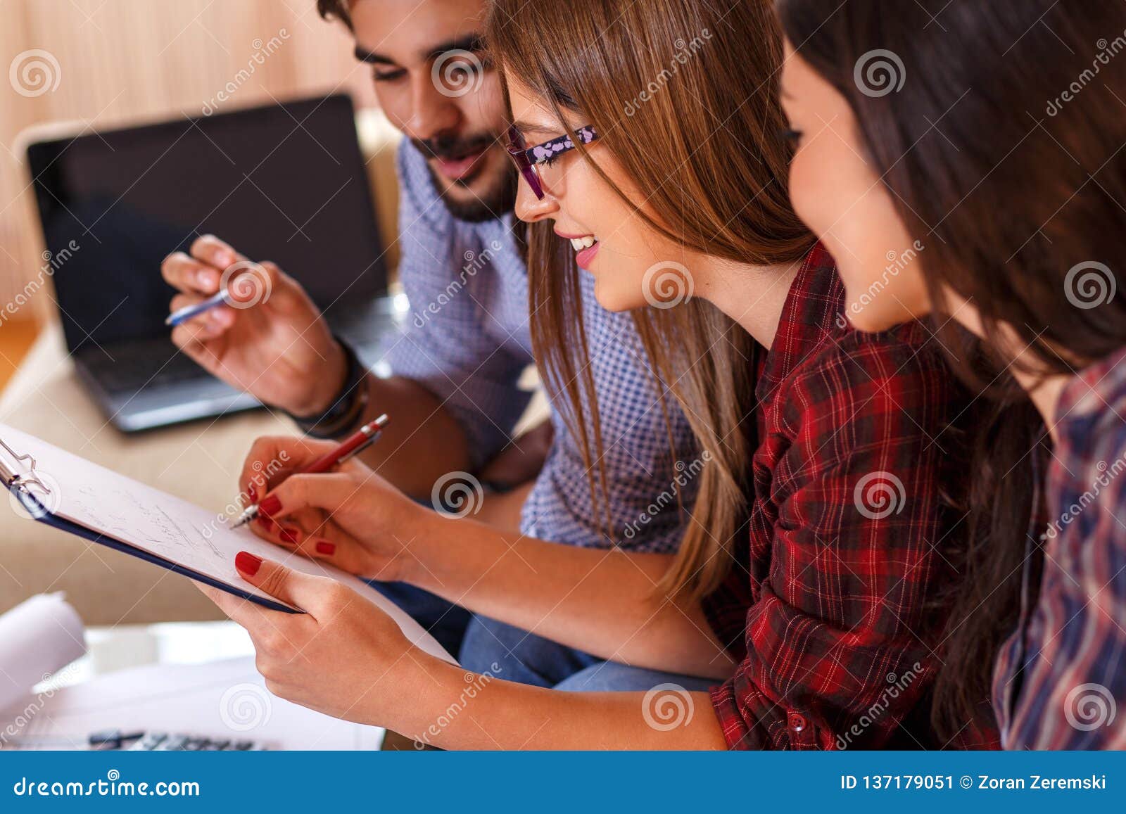 Three Young Students Working Together on a New Project. Stock Image ...