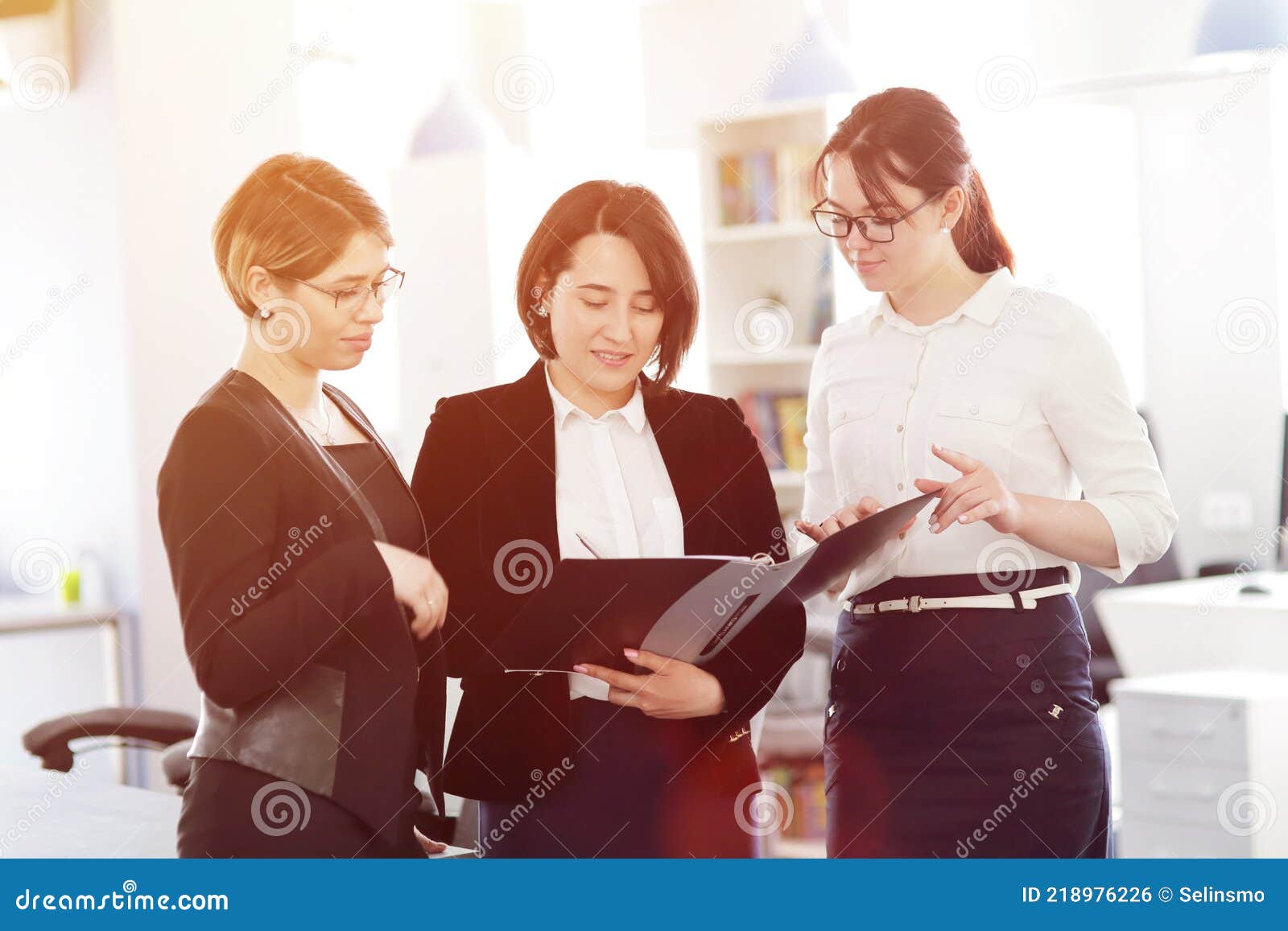 Three Young Successful Business Women in the Office Working Together on ...