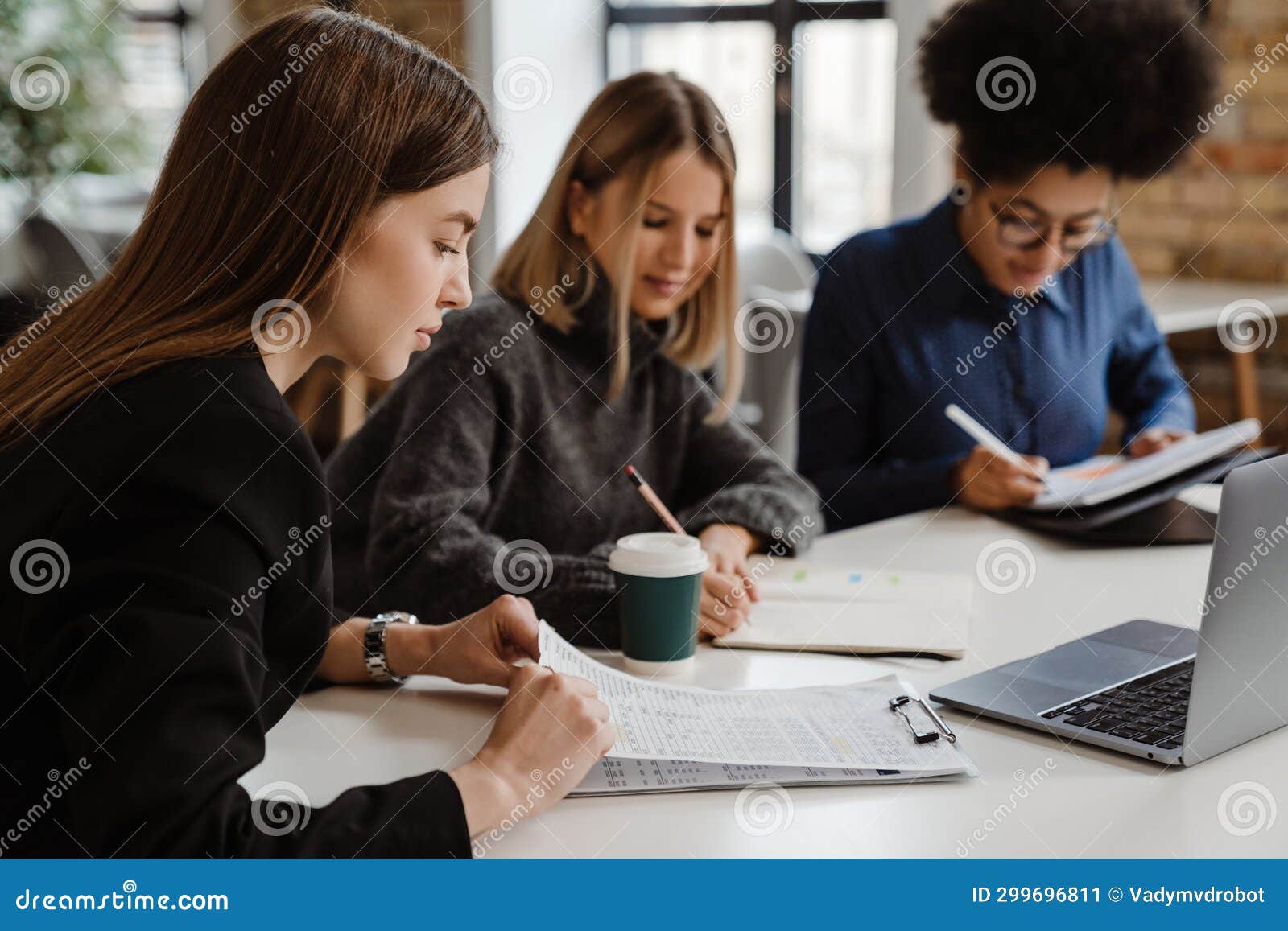 Three Young Women Doing Paperwork while Sitting in Office Stock Image ...