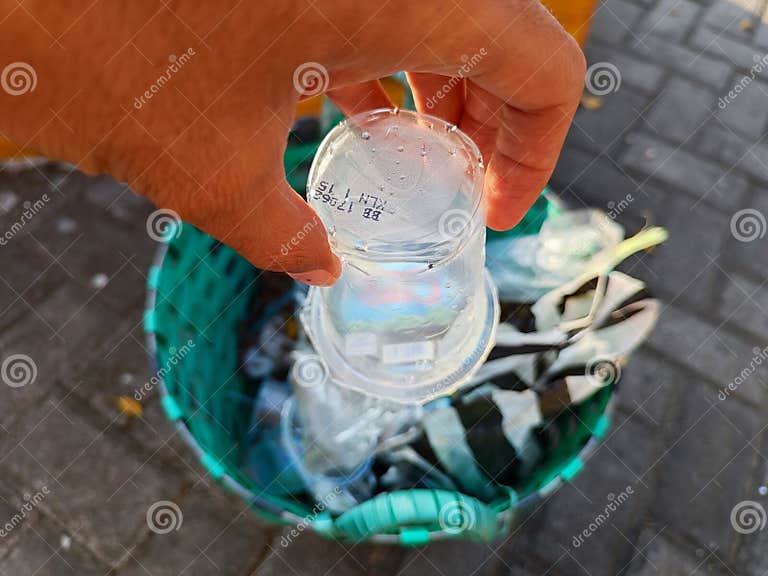 Throw Plastic Cup Waste into the Trash with Your Left Hand Stock Image ...