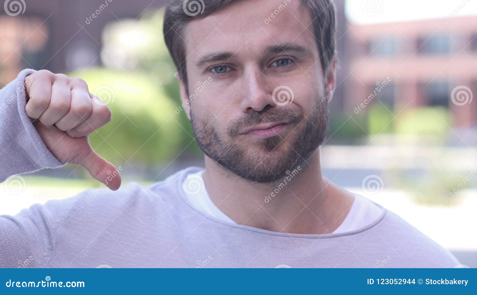 Thumbs Down by Handsome Man at Work Looking at Camera Stock Photo ...