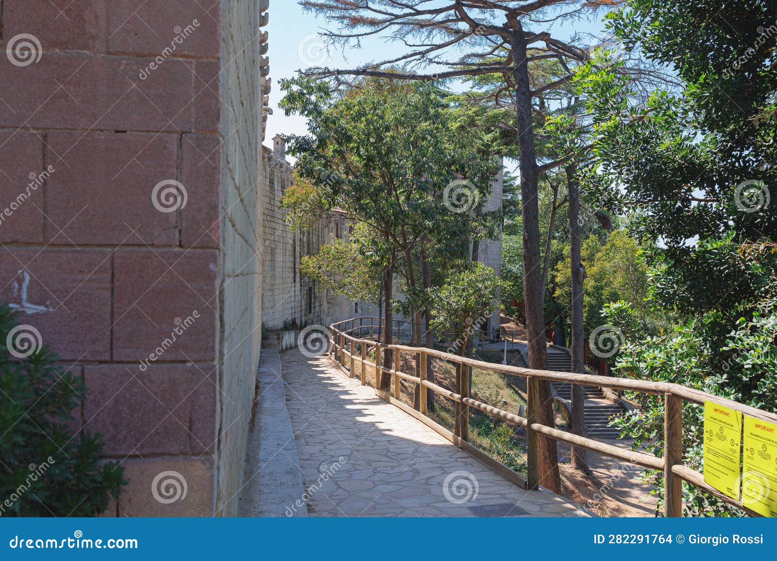 Tiled Outdoor Walking Path Along a Fortress Wall and Trees Around it ...