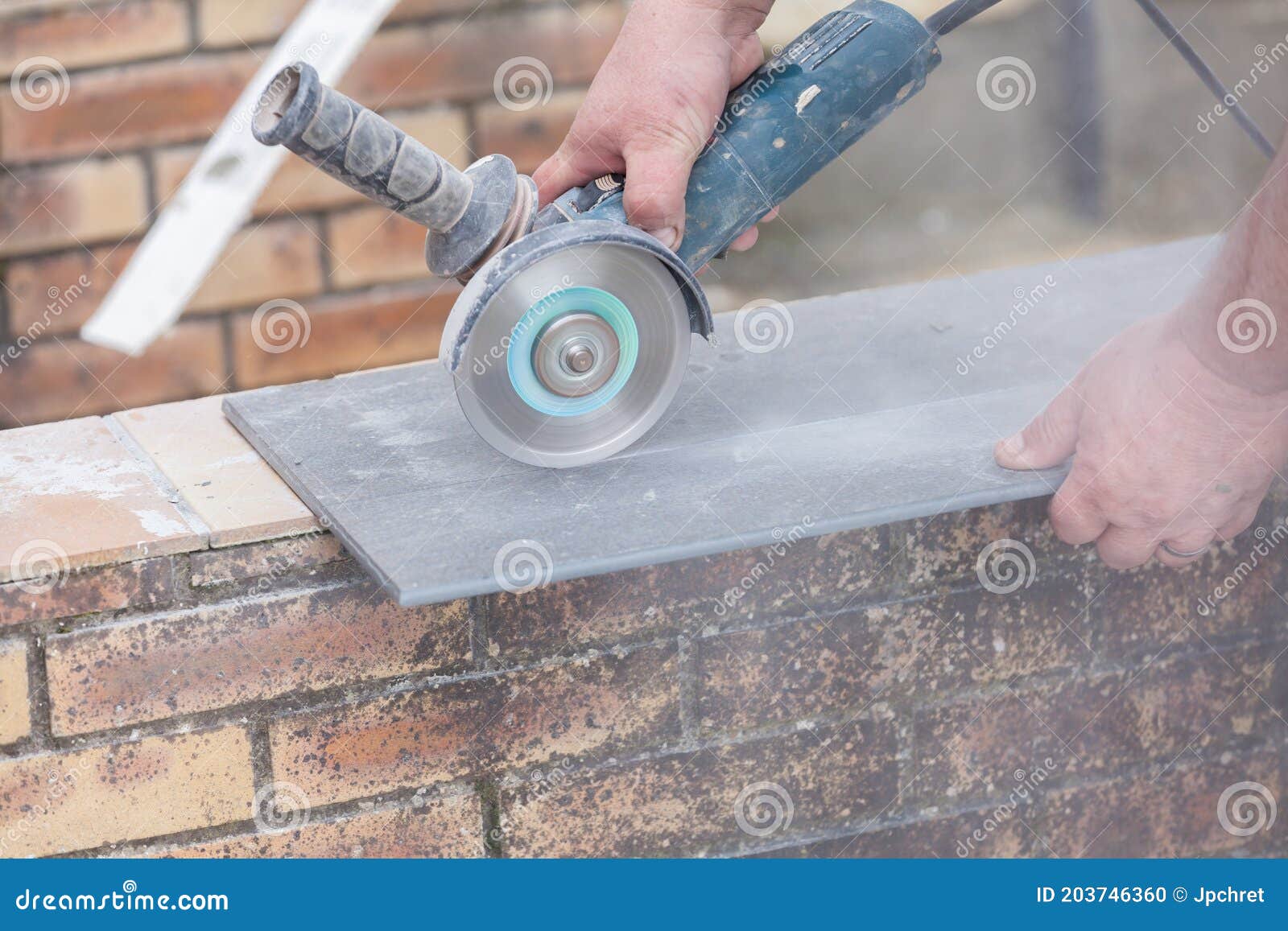 Tiler Cutting A Floor Tile With A Portable Angle Grinder. Craftsman ...
