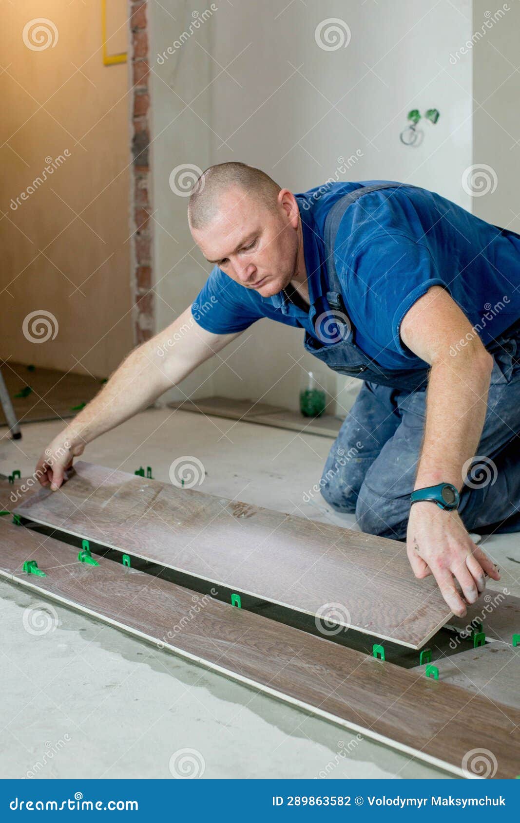 Tiler Placing Ceramic Wall Tile in Position Over Adhesive with Lash ...