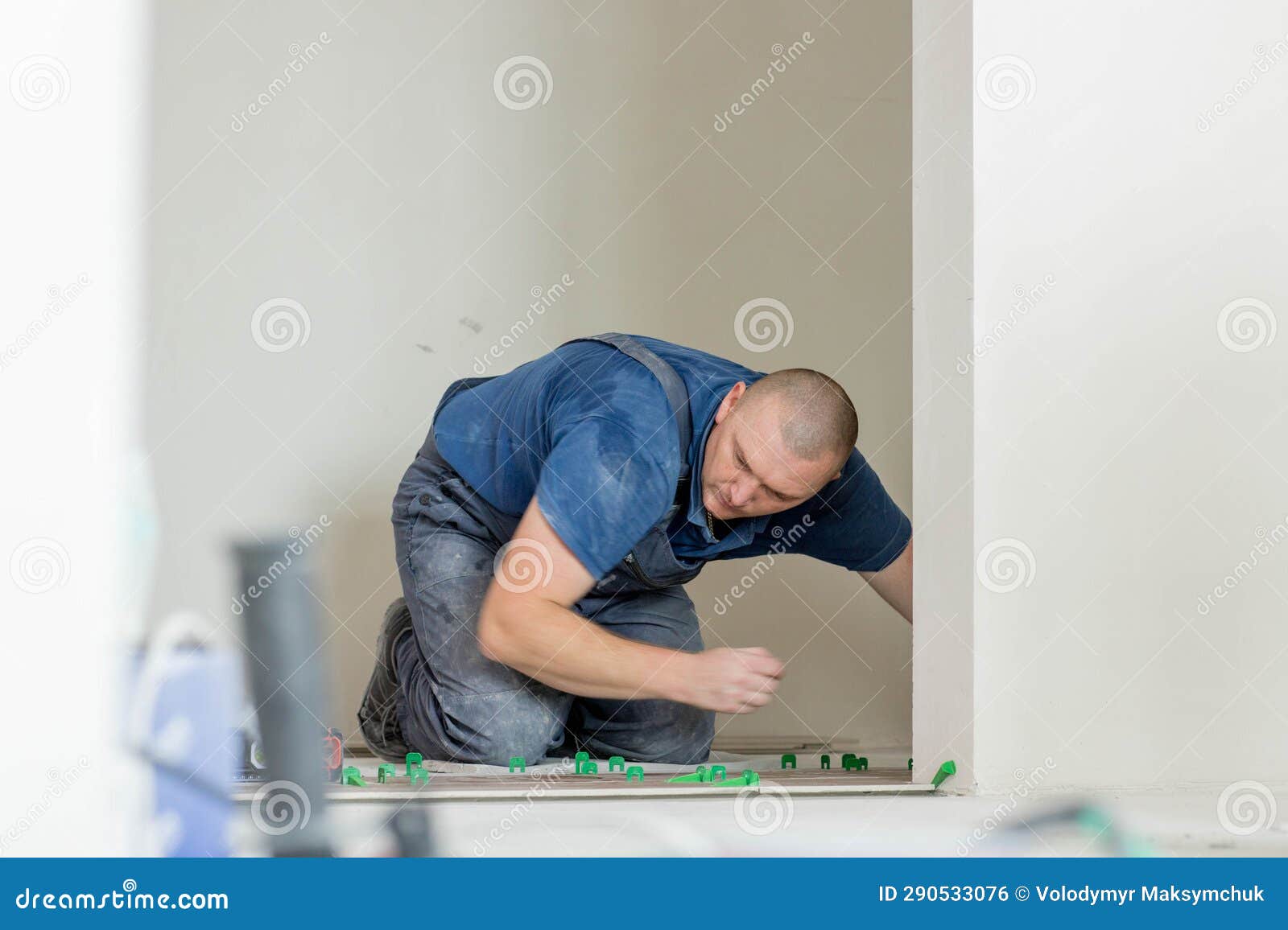 Tiler Placing Ceramic Wall Tile in Position Over Adhesive with Lash ...