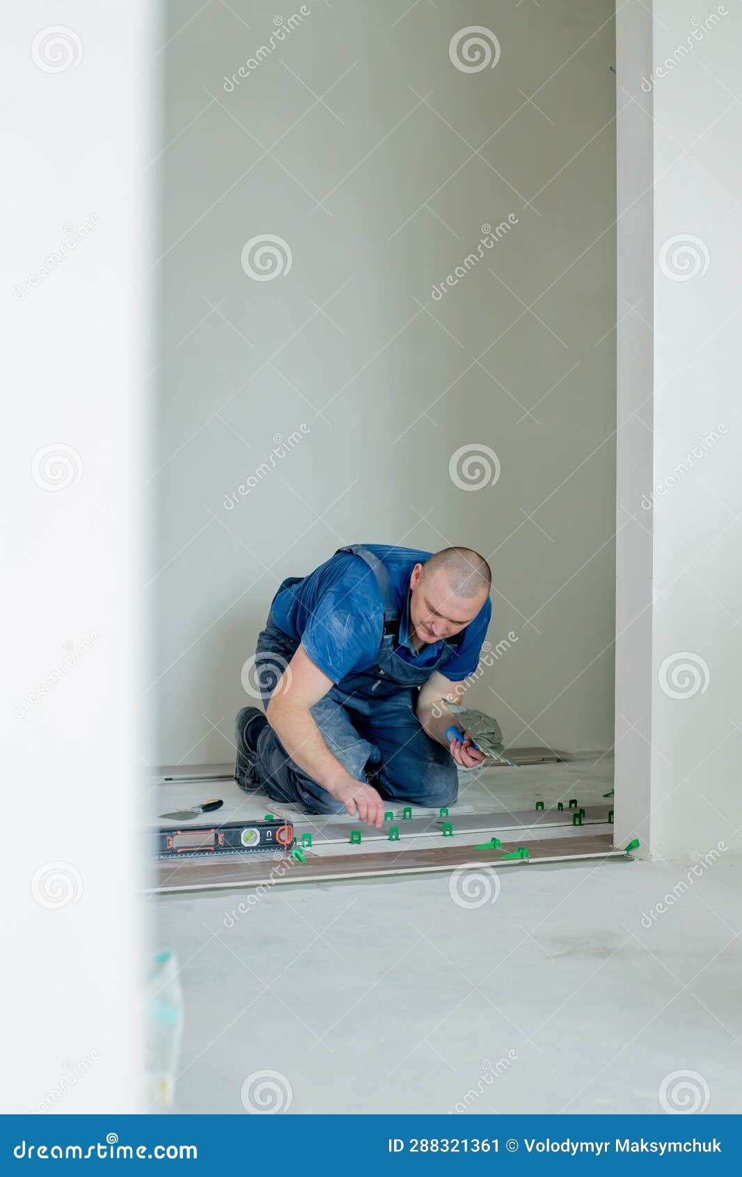 Tiler Placing Ceramic Wall Tile in Position Over Adhesive with Lash ...