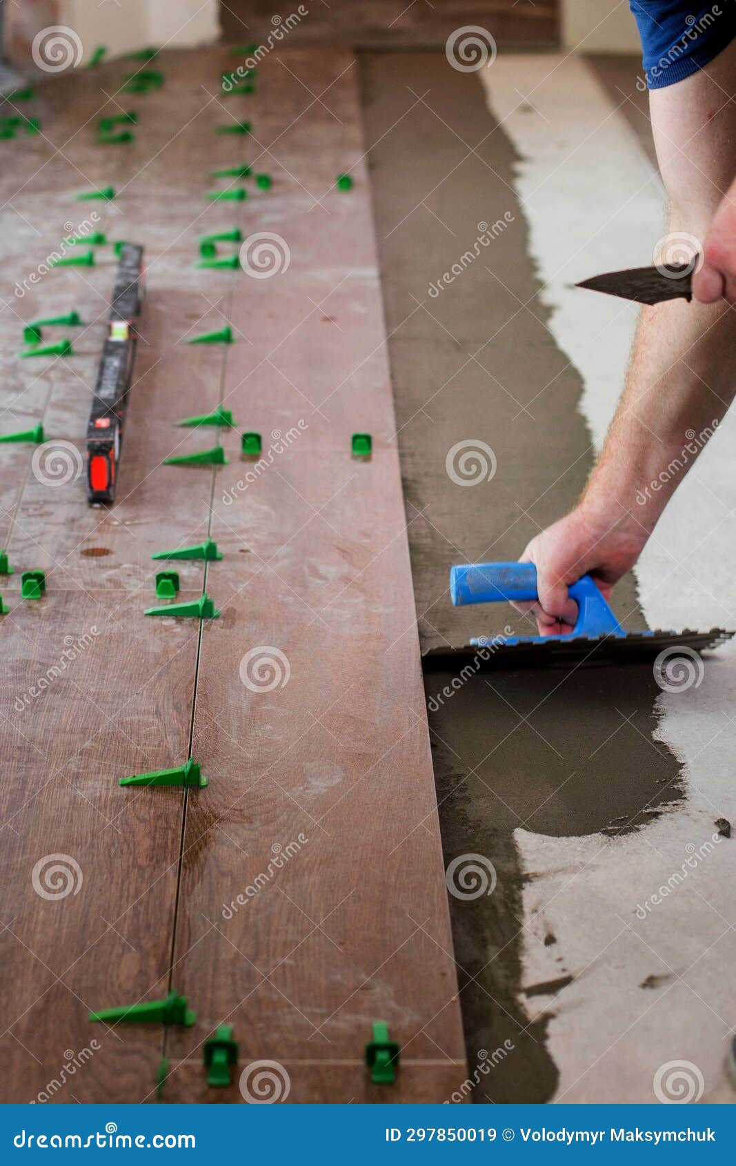 Tiler Placing Ceramic Wall Tile in Position Over Adhesive with Lash ...