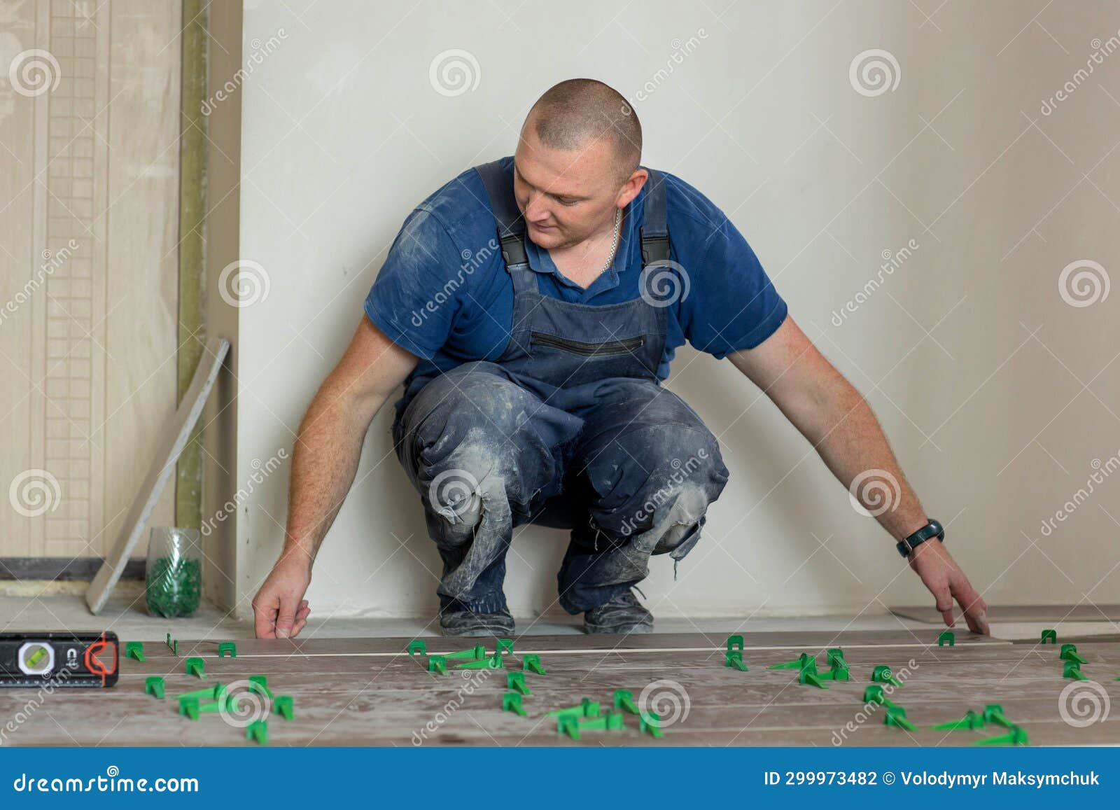 Tiler Placing Ceramic Wall Tile in Position Over Adhesive with Lash ...