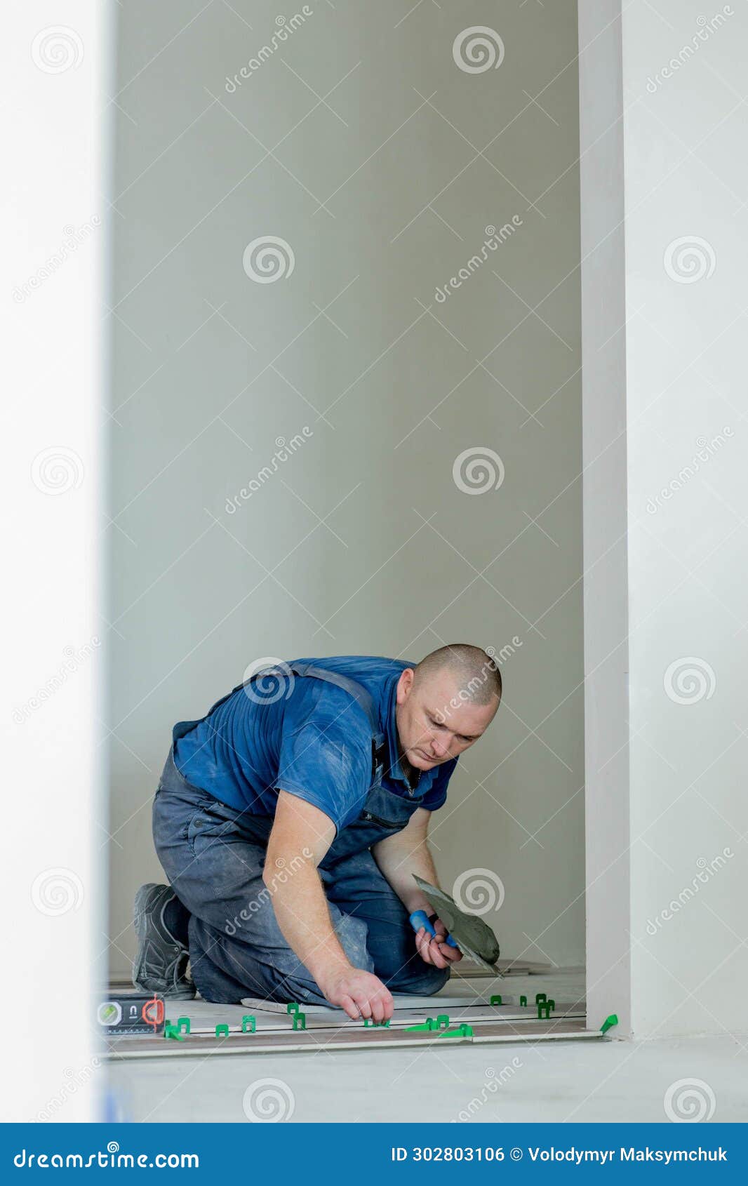 Tiler Placing Ceramic Wall Tile in Position Over Adhesive with Lash ...