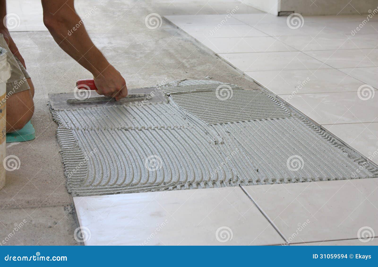 Young Male Tiler on His Knees Spreading Tiling Adhesive Stock Photo ...