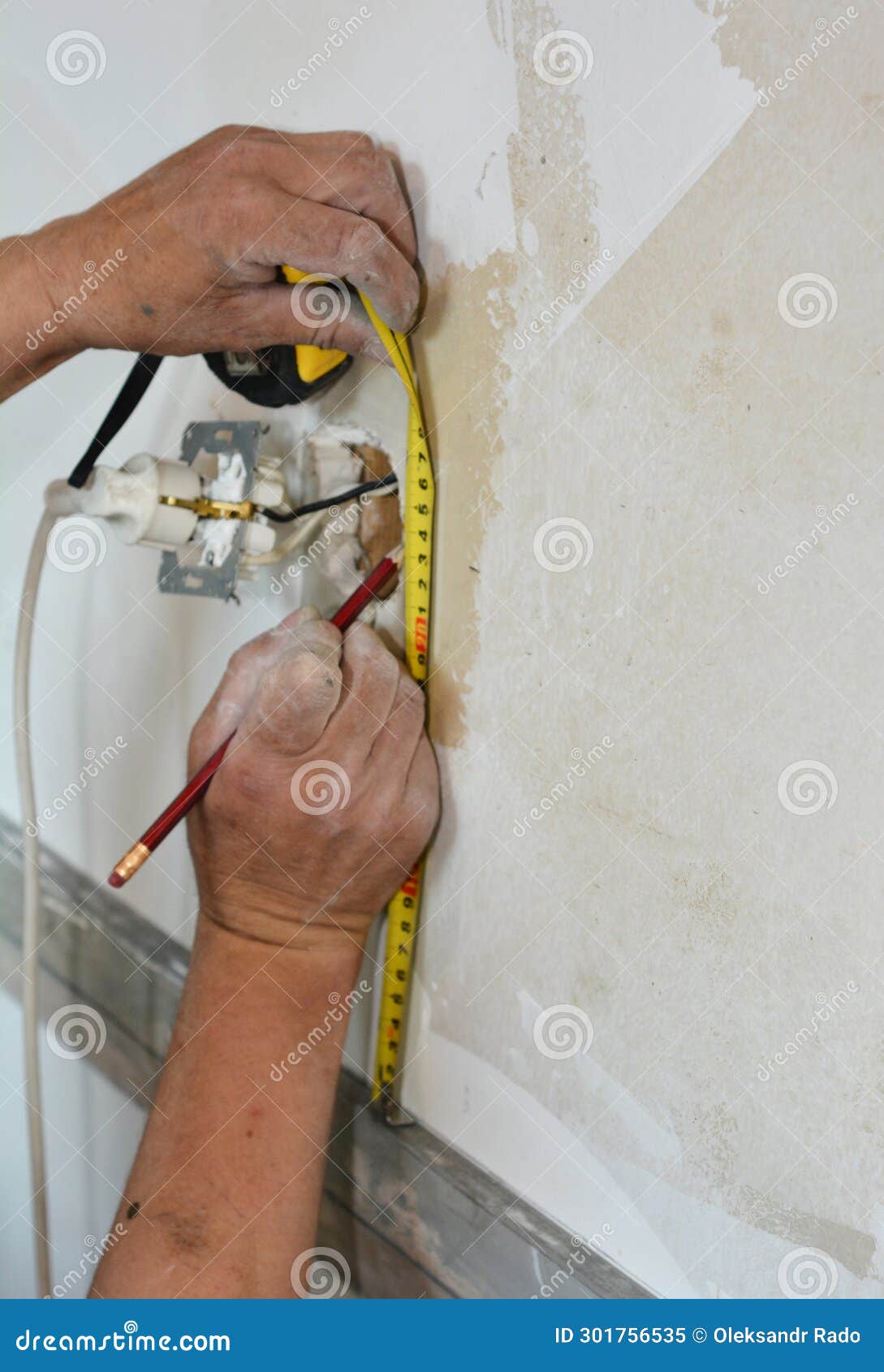 Tiling Around Electrical Outlets Over Drywall. a Man is Taking Measures ...