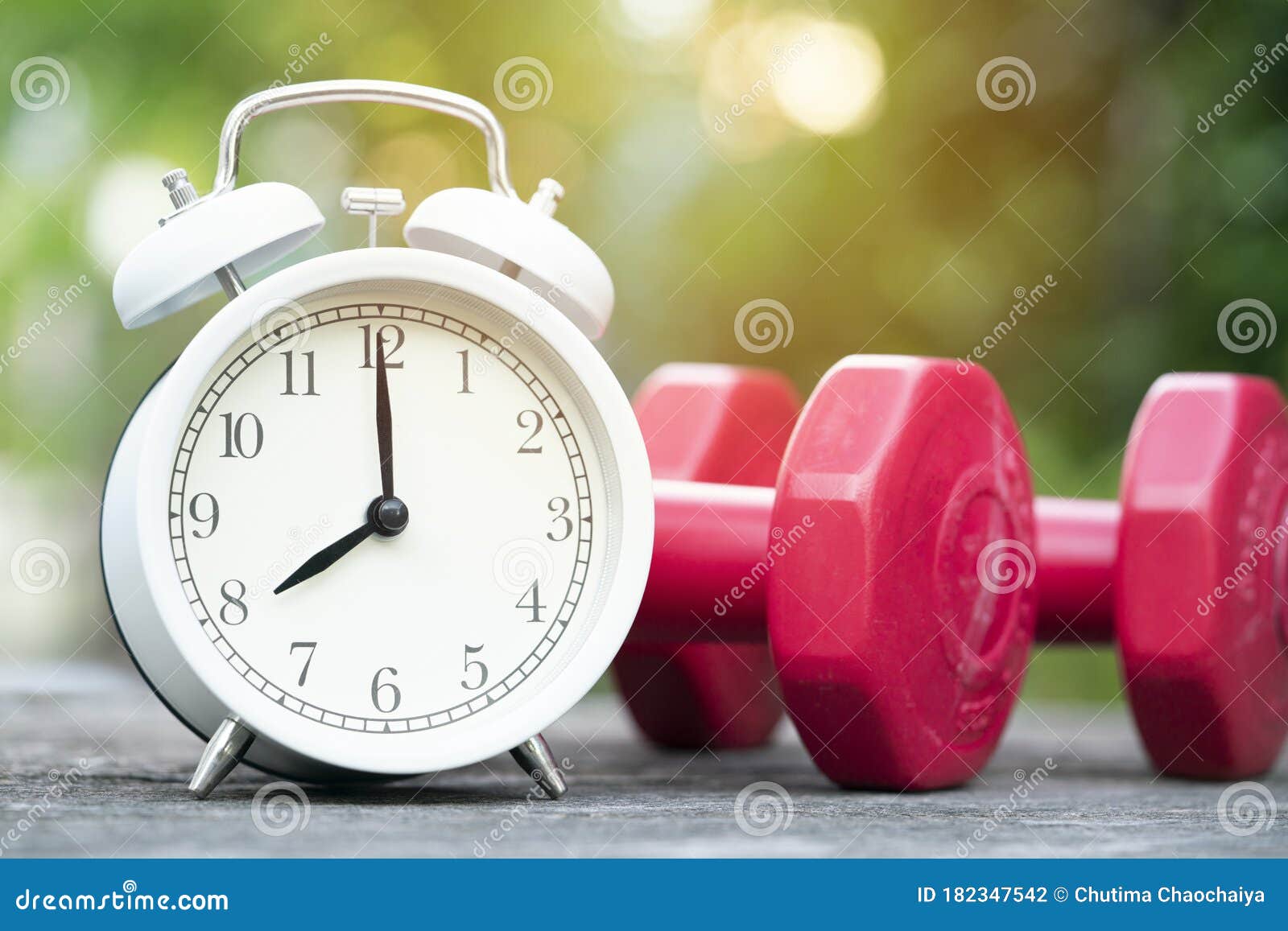Time for Exercising Alarm Clock and Dumbbell on the Table Background ...