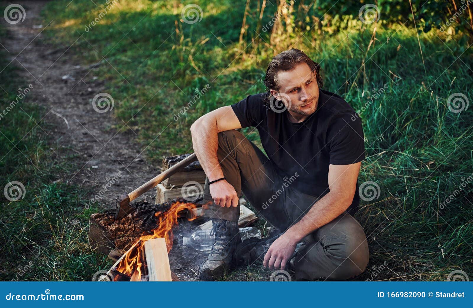 Time for a Rest. Man in Black Shirt Near the Campfire in the Forest at ...
