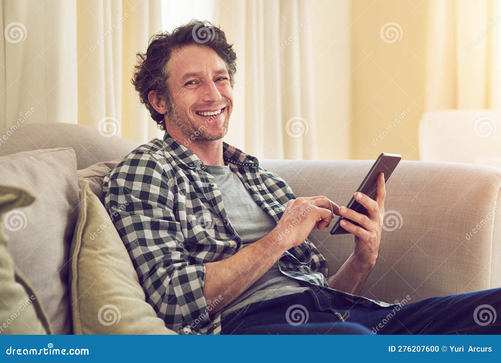 Time for a Status Update. a Man Working on His Tablet on the Couch ...