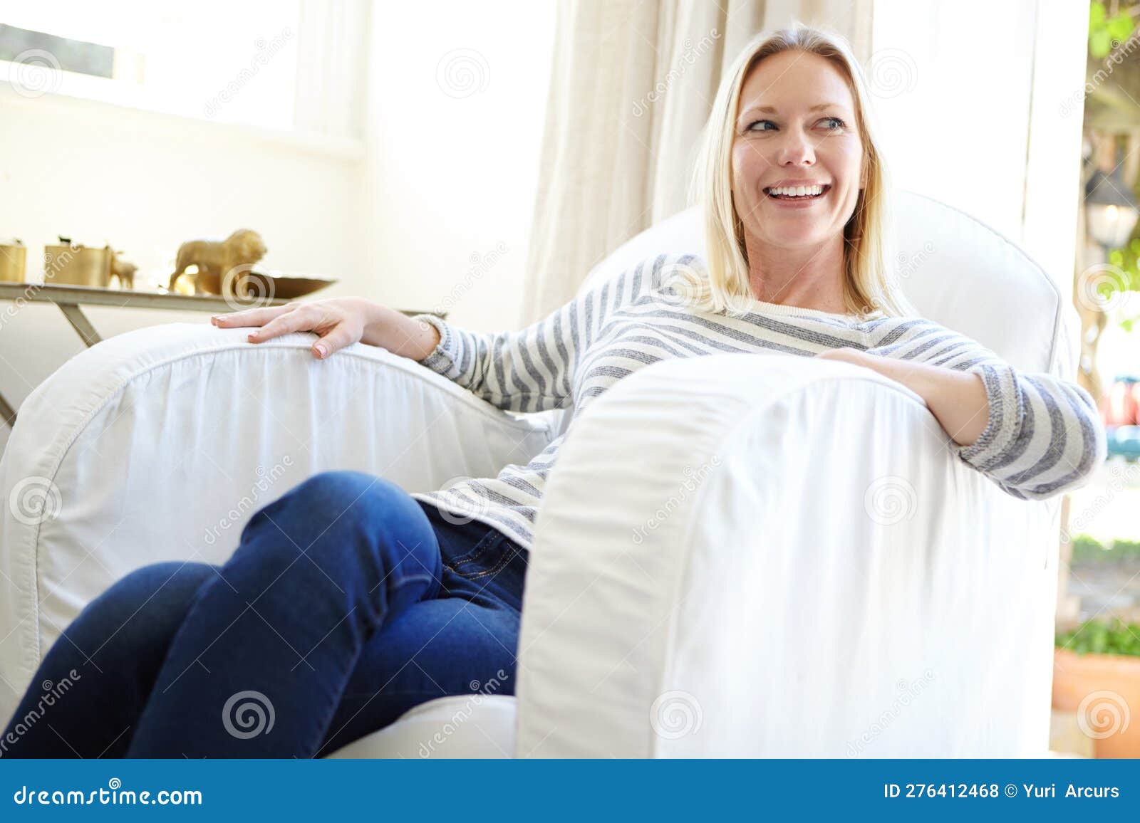 Time To Unwind A Beautiful Woman Relaxing On A Chair At Home Stock