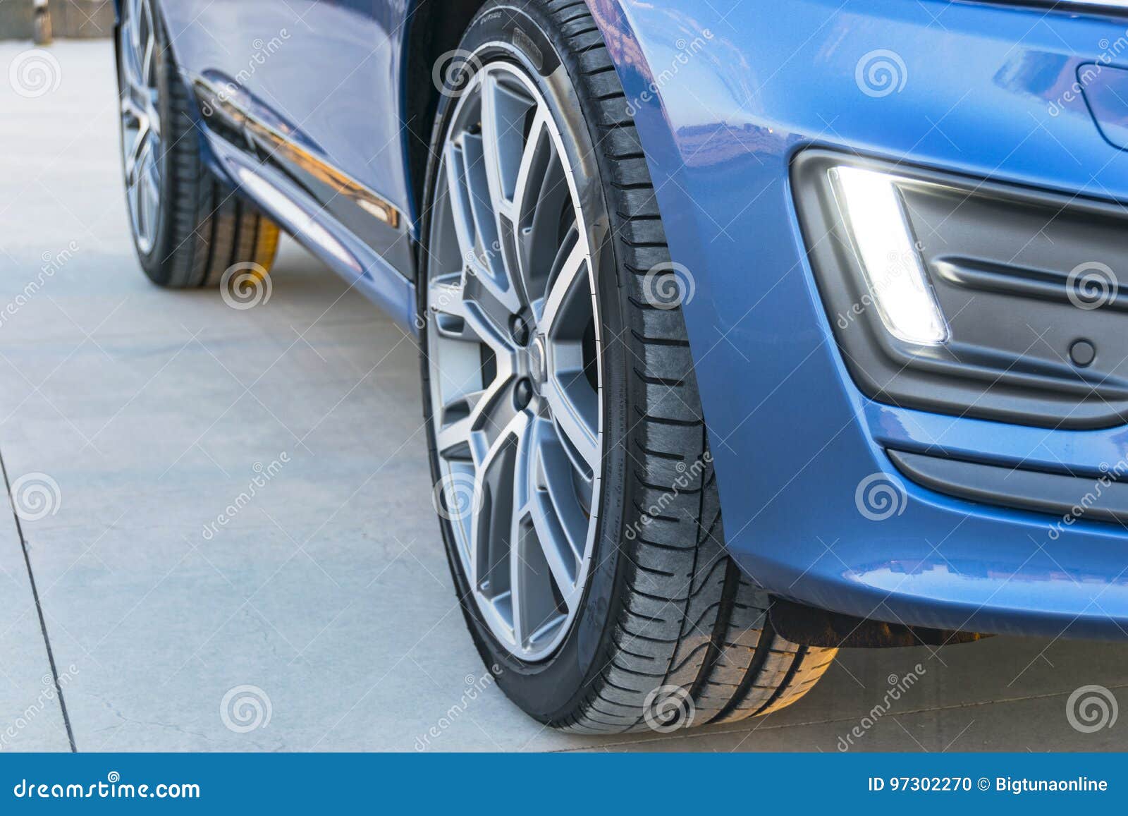 Tire and Alloy Wheel of a Modern Car on the Ground. Stock Photo - Image ...