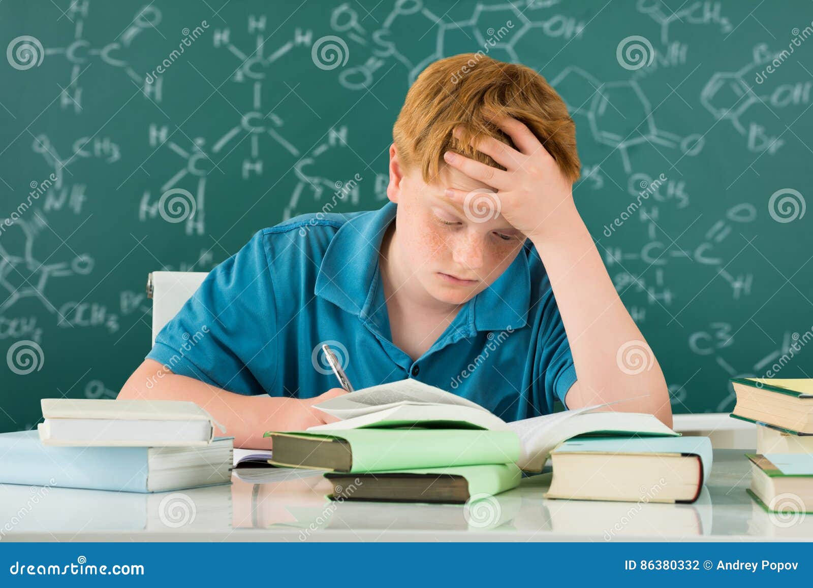 Tired Boy Studying in Classroom Stock Photo - Image of holding, looking ...
