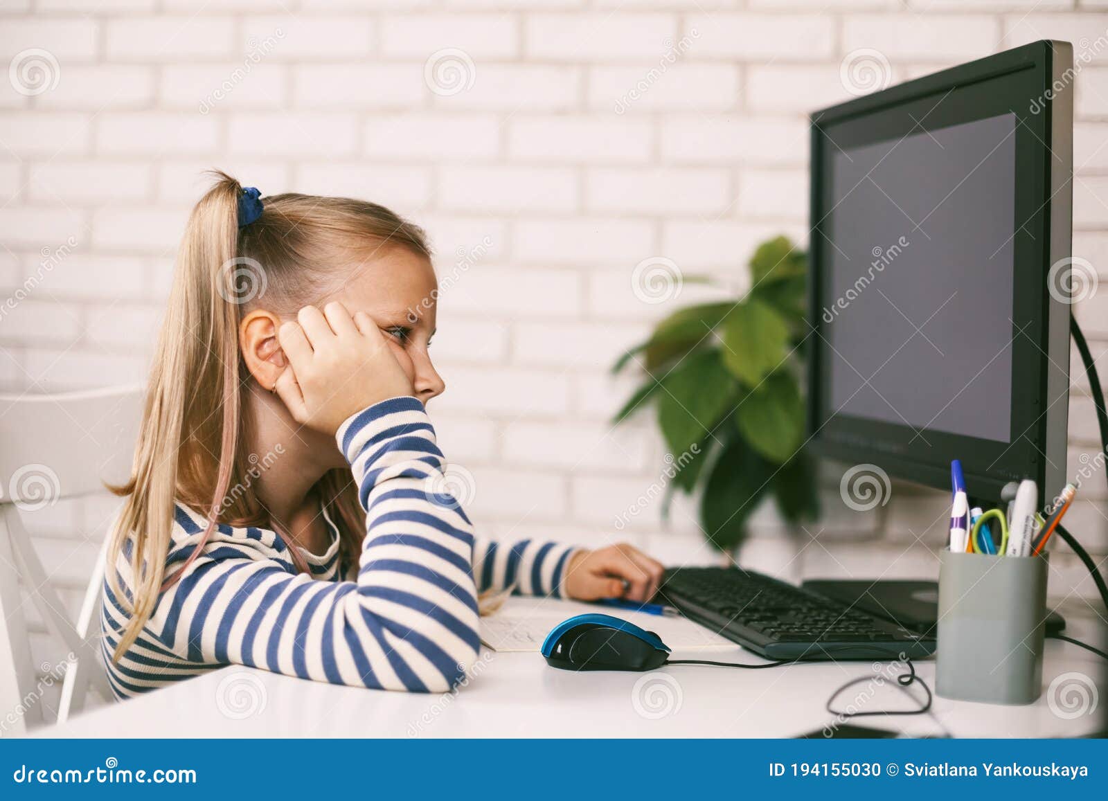 A Tired Child Sits at Home at a Computer Desk and Does Homework. Online ...
