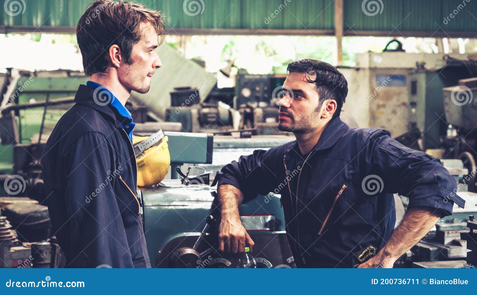 Tired Factory Workers Taking a Break and Talking To Coworker in the ...