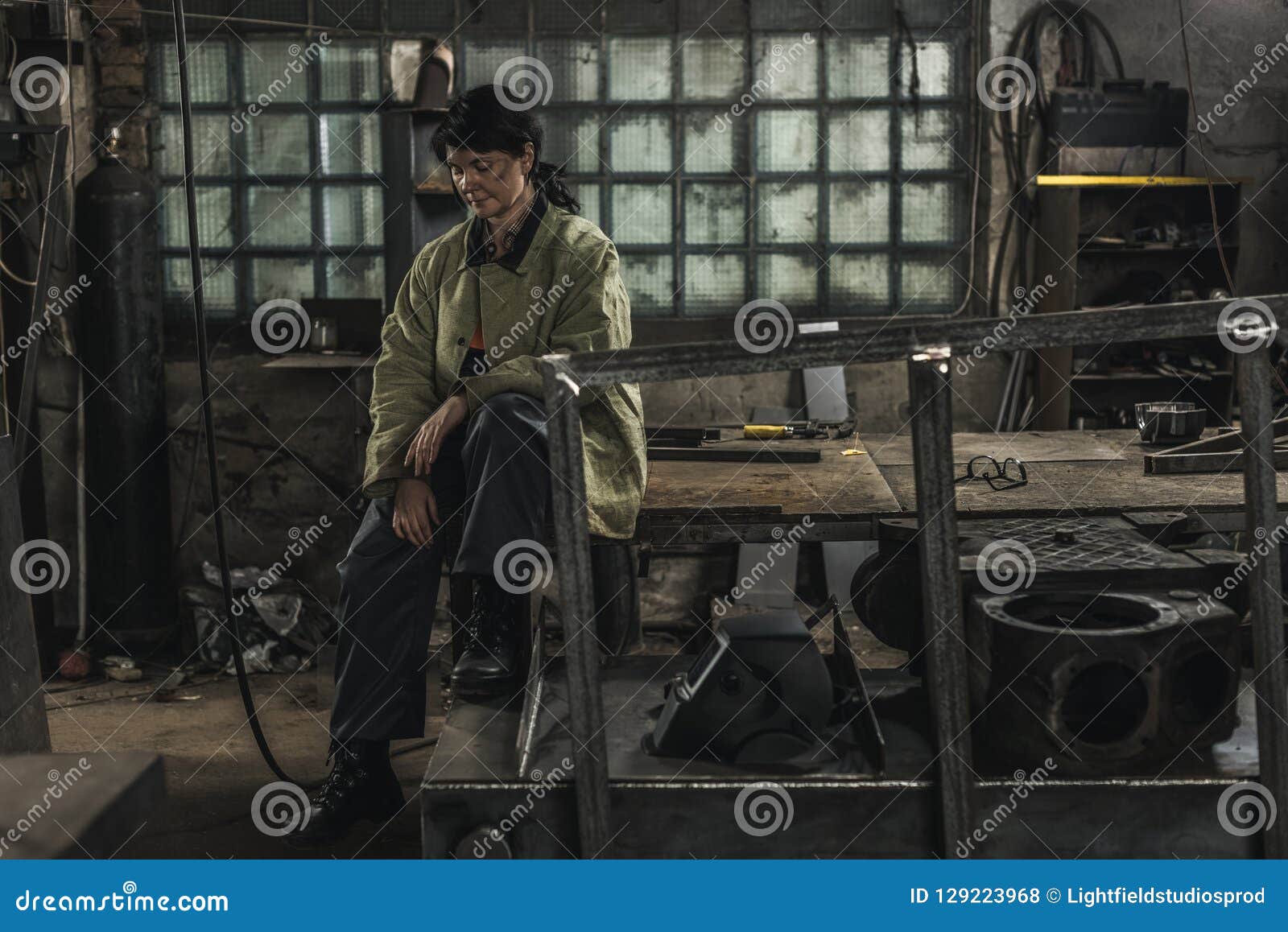 Tired Female Welder Sitting on Table while Having Rest Stock Photo ...