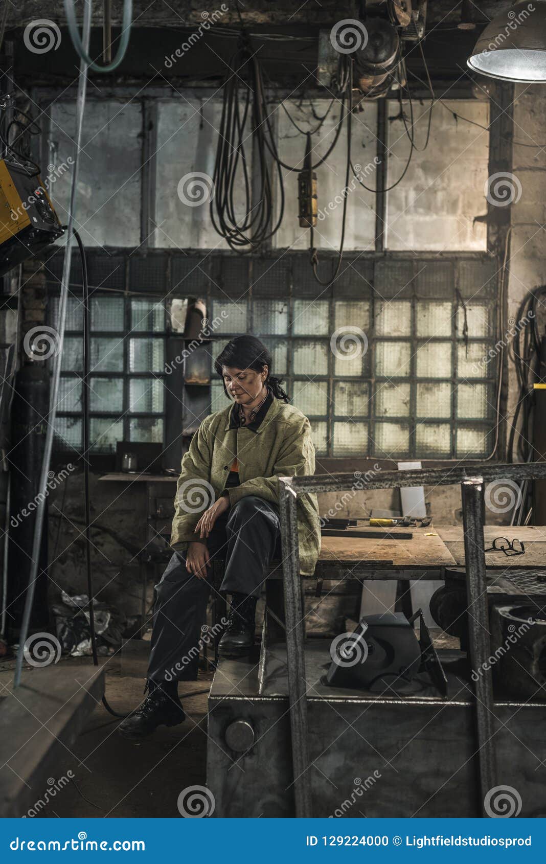 Tired Female Welder Sitting on Table while Having Rest Stock Photo ...