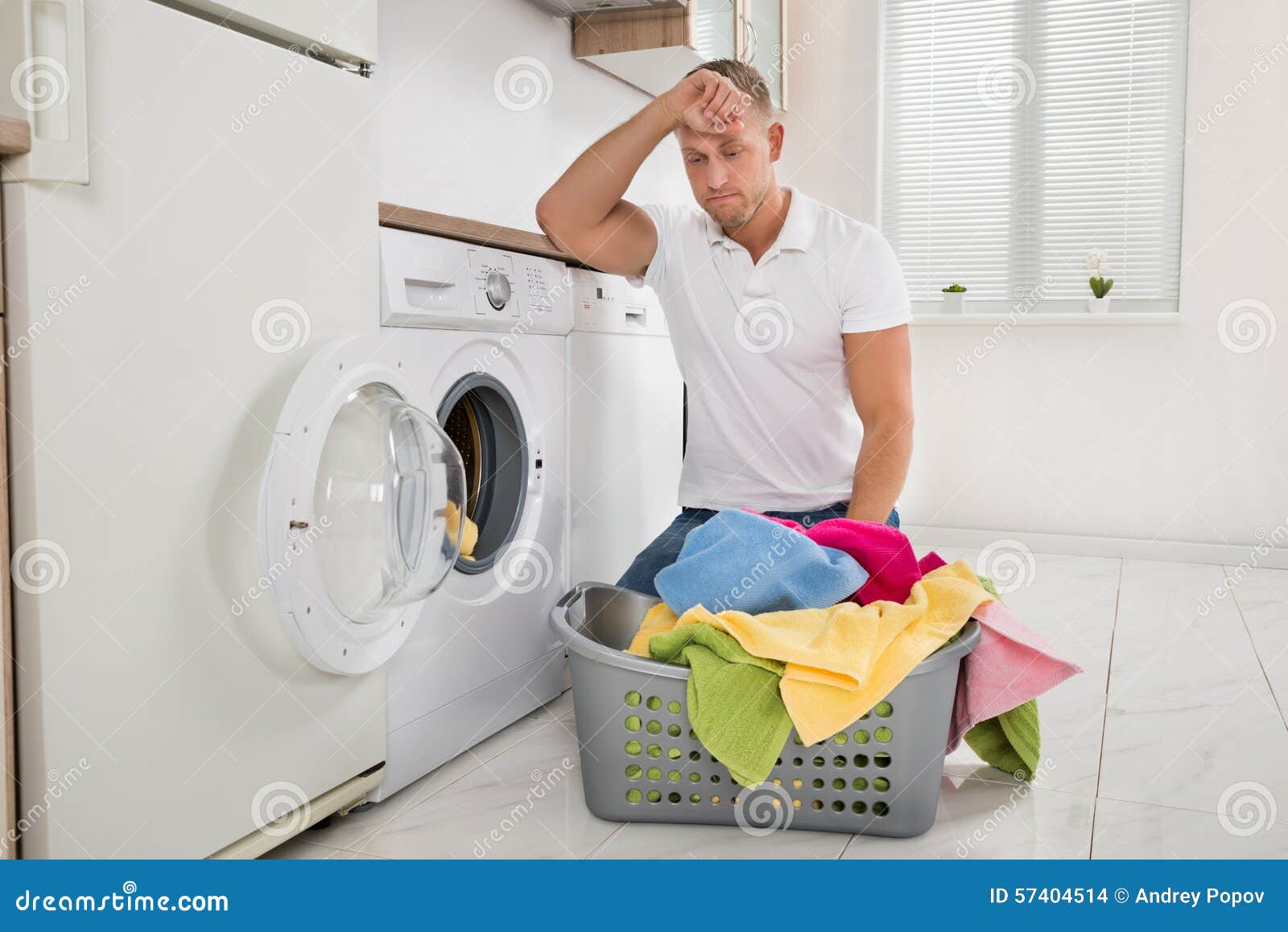 Tired Man Loading Clothes into the Washing Machine Stock Photo - Image ...
