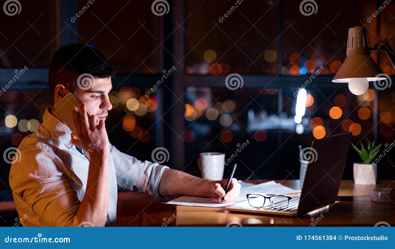 Tired Manager Guy Calling on Phone Taking Notes in Office Stock Photo ...
