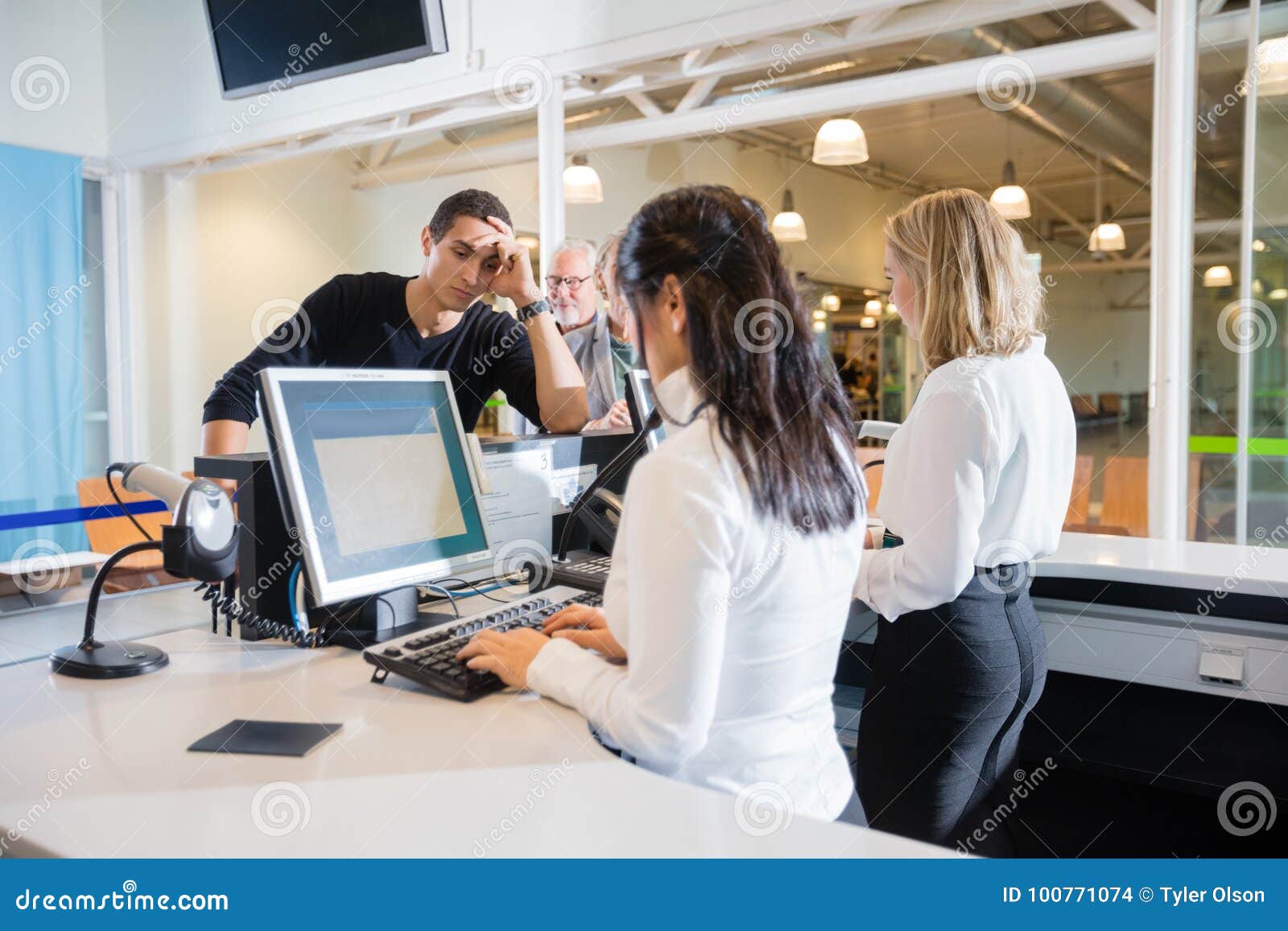 Tired Passenger Waiting at Check-in while Staff Using Computer Stock ...