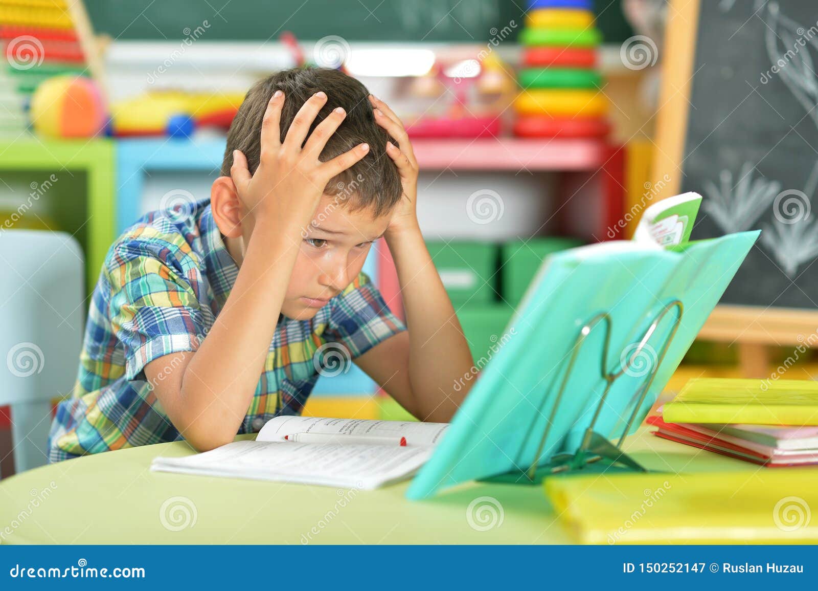 Portrait of Tired Schoolboy Doing Homework in Classroom Stock Image ...
