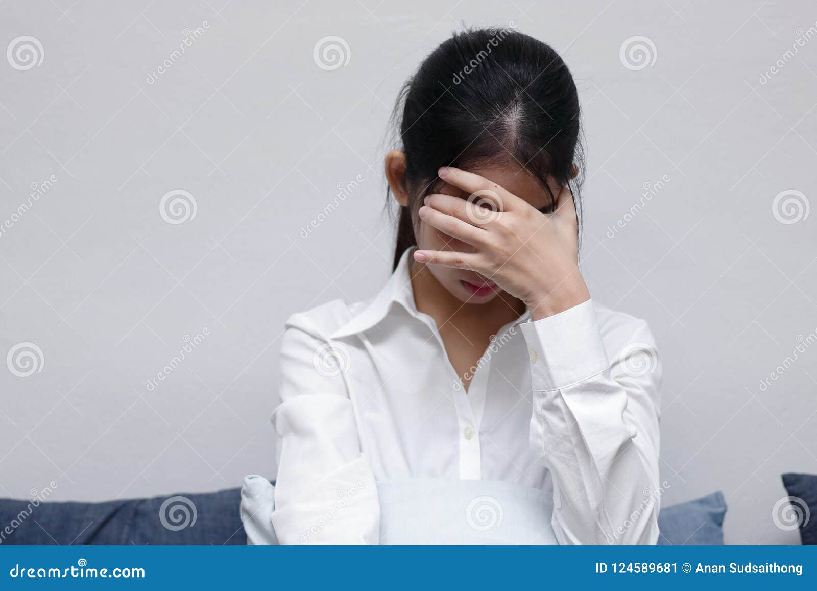 Tired Stressed Young Asian Woman Covering Face With Hands In Living