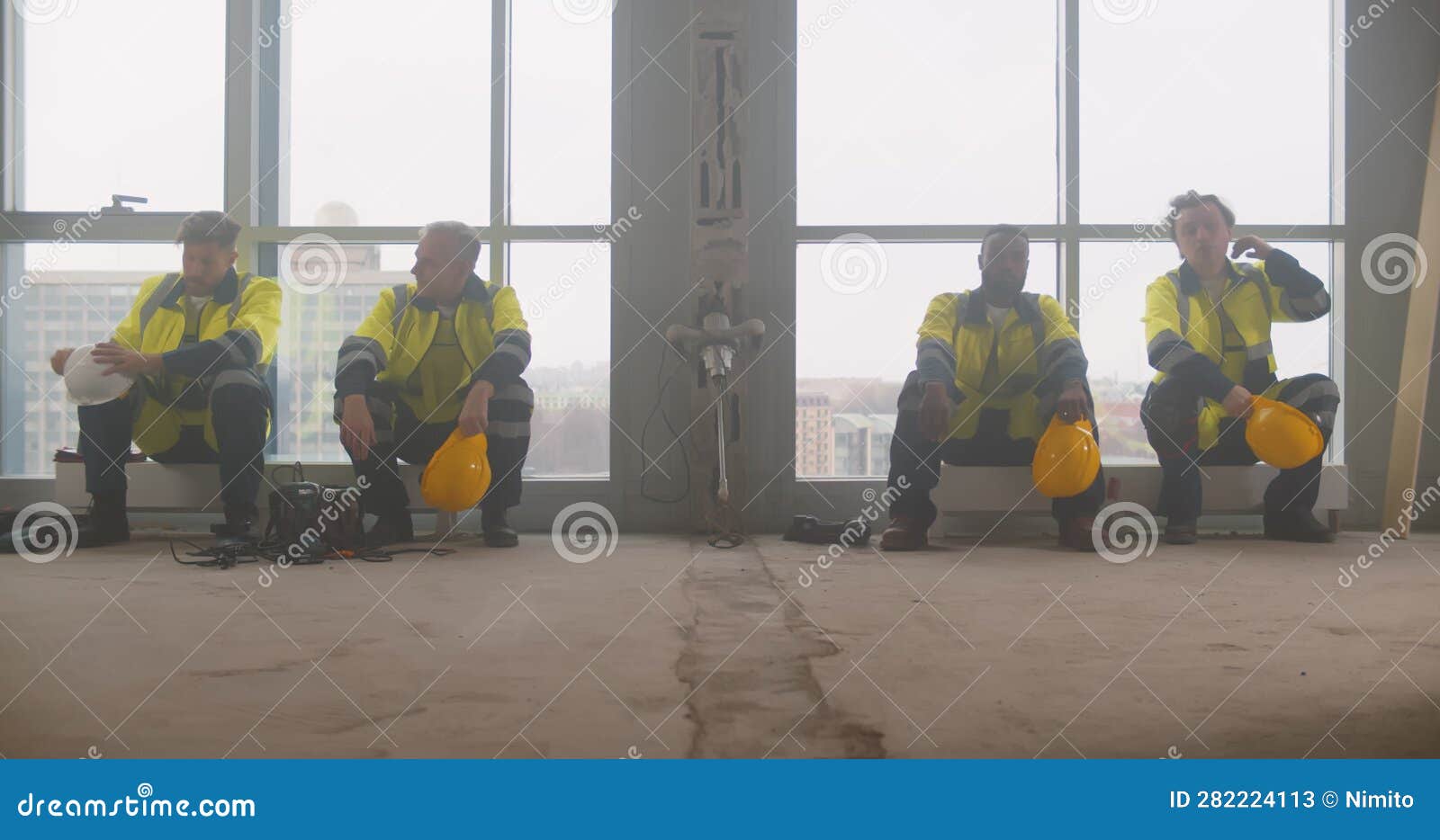 Tired Team of Builders Sitting on Heaters and Resting at Construction ...