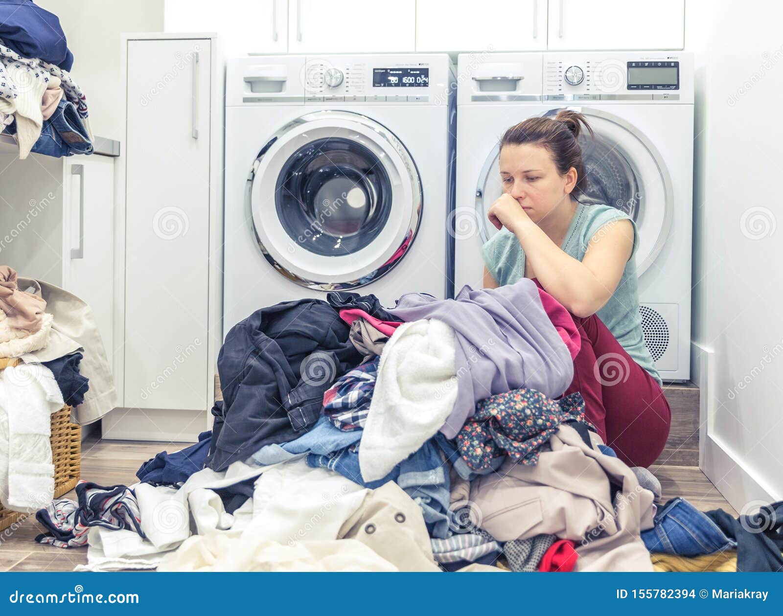 Tired Unhappy Woman Housewife In A Laundry Room Near Washing Machine