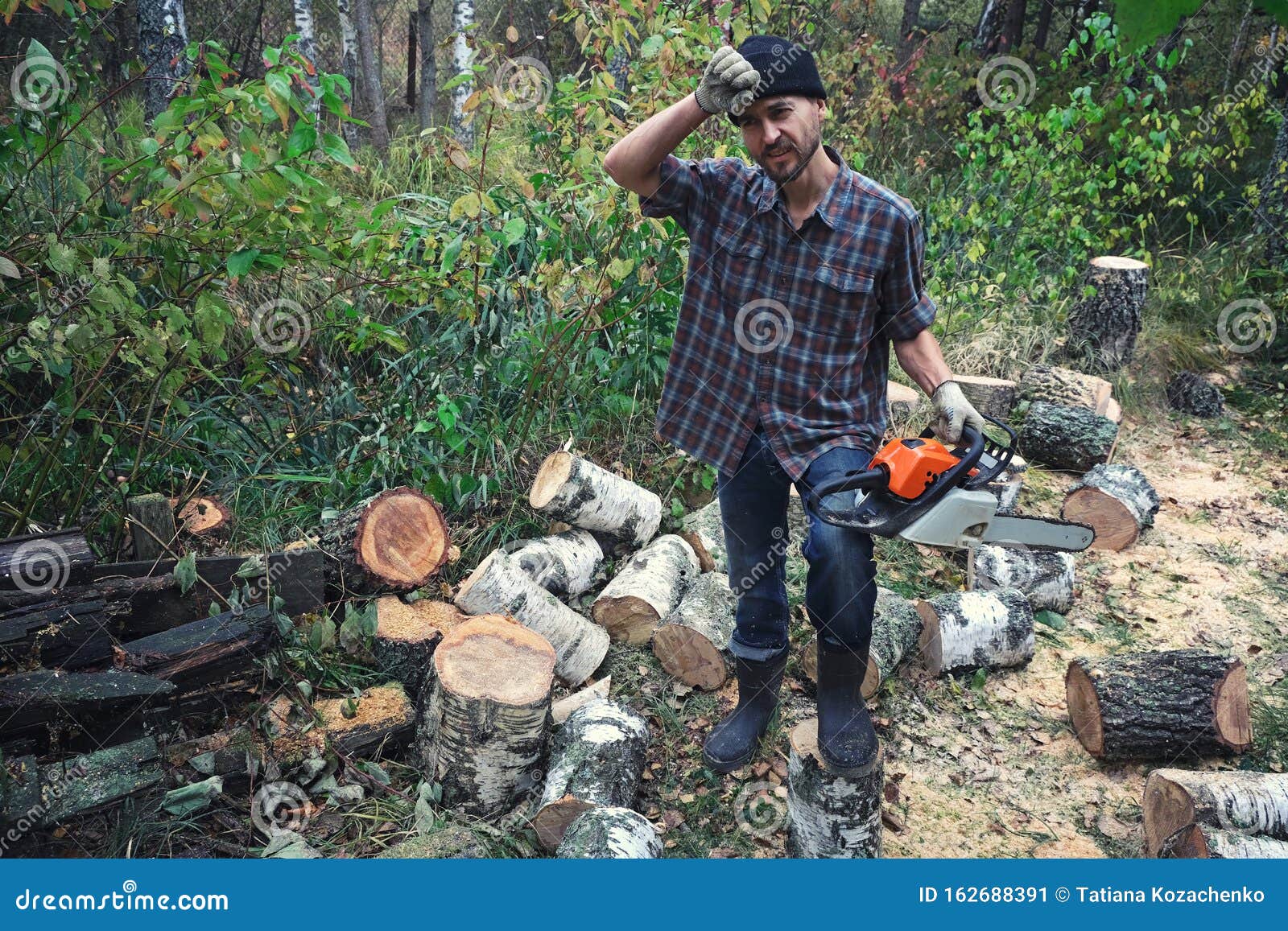Tired Woodcutter after Hard Work in Forest with Chainsaw. Lumberjack ...
