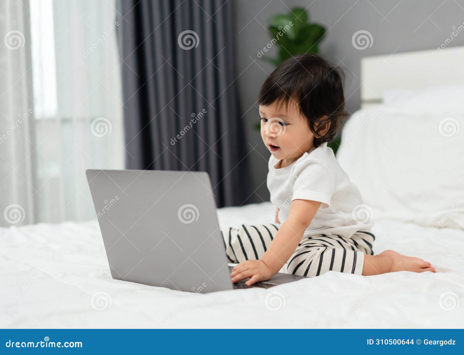 Toddler Baby Using Laptop Computer on Bed Stock Photo - Image of ...