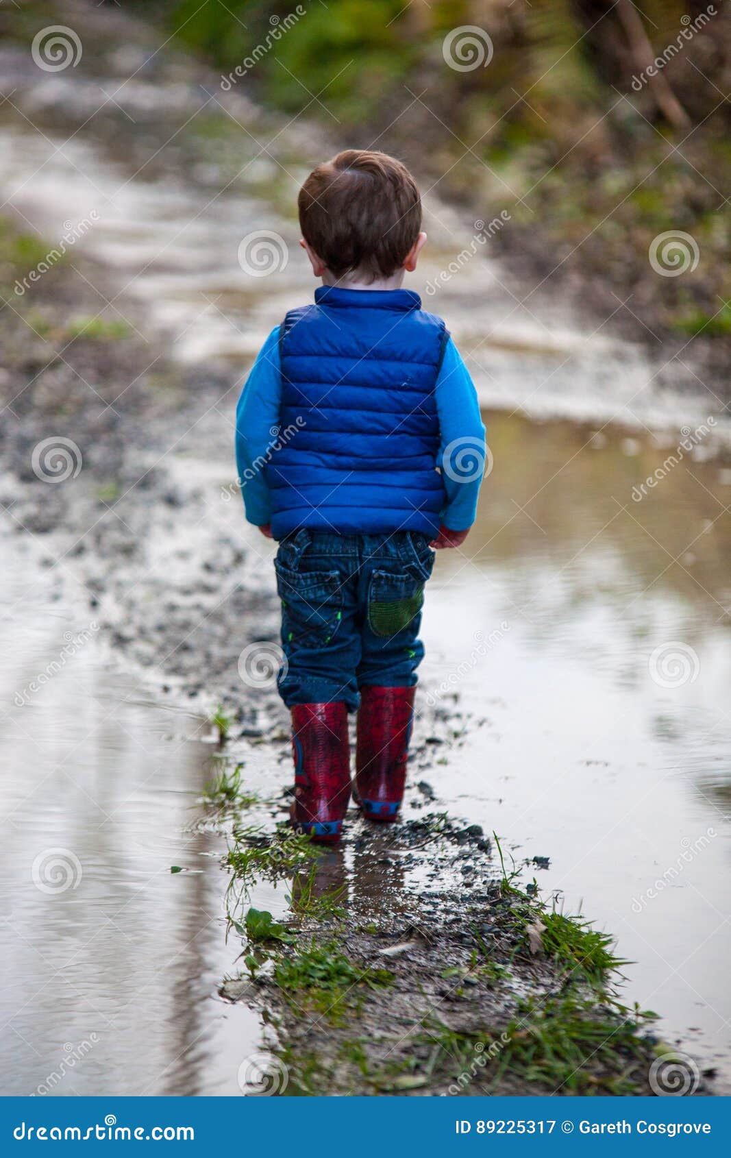 Toddler boy in puddle stock image. Image of standing - 89225317