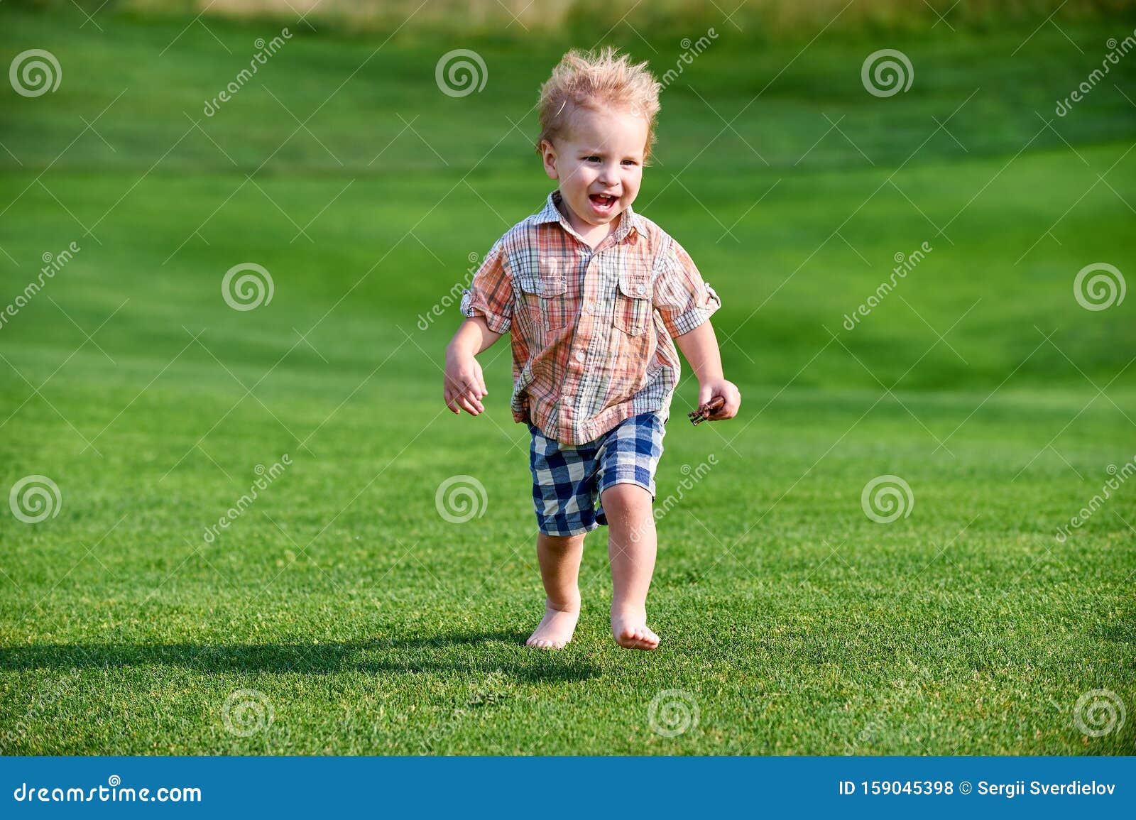 Toddler Standing at the Green Golf Course at Sunny Day Stock Photo ...
