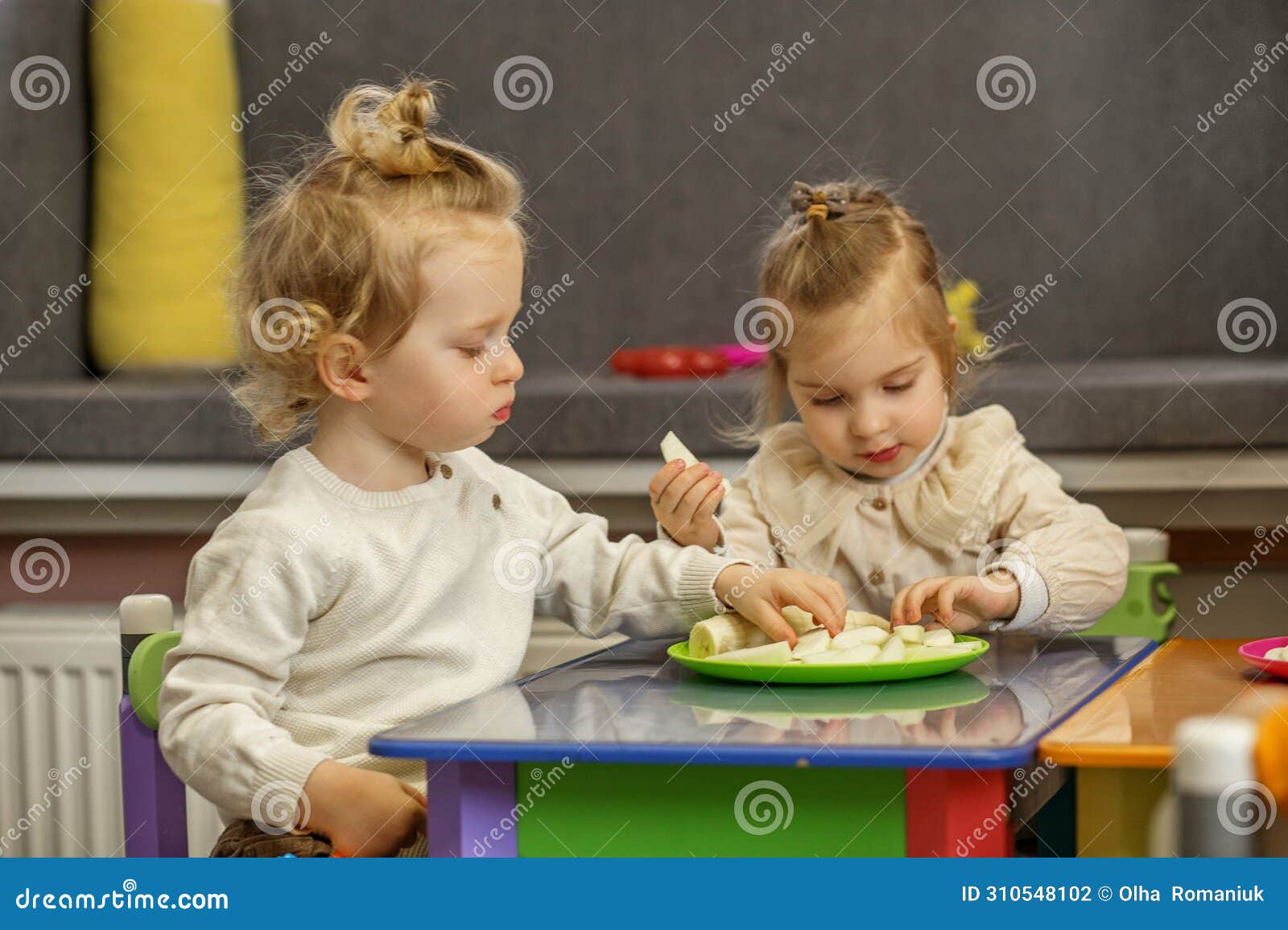 Toddlers Sharing Snack Time at Play Table Stock Photo - Image of ...