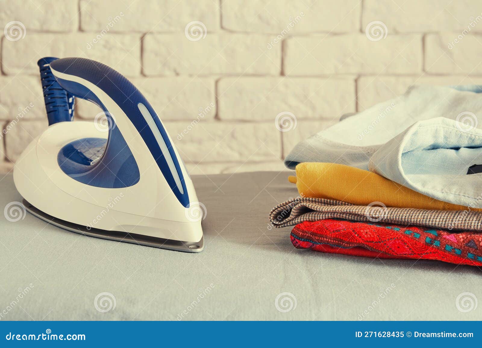 Toned Image of House Appliances with Iron and Stack of Clothes on ...